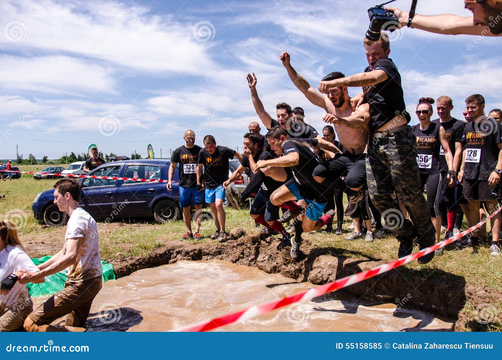 Men Jumping in Muddy Water at Ultimate Mudness, Athletic Competition in ...