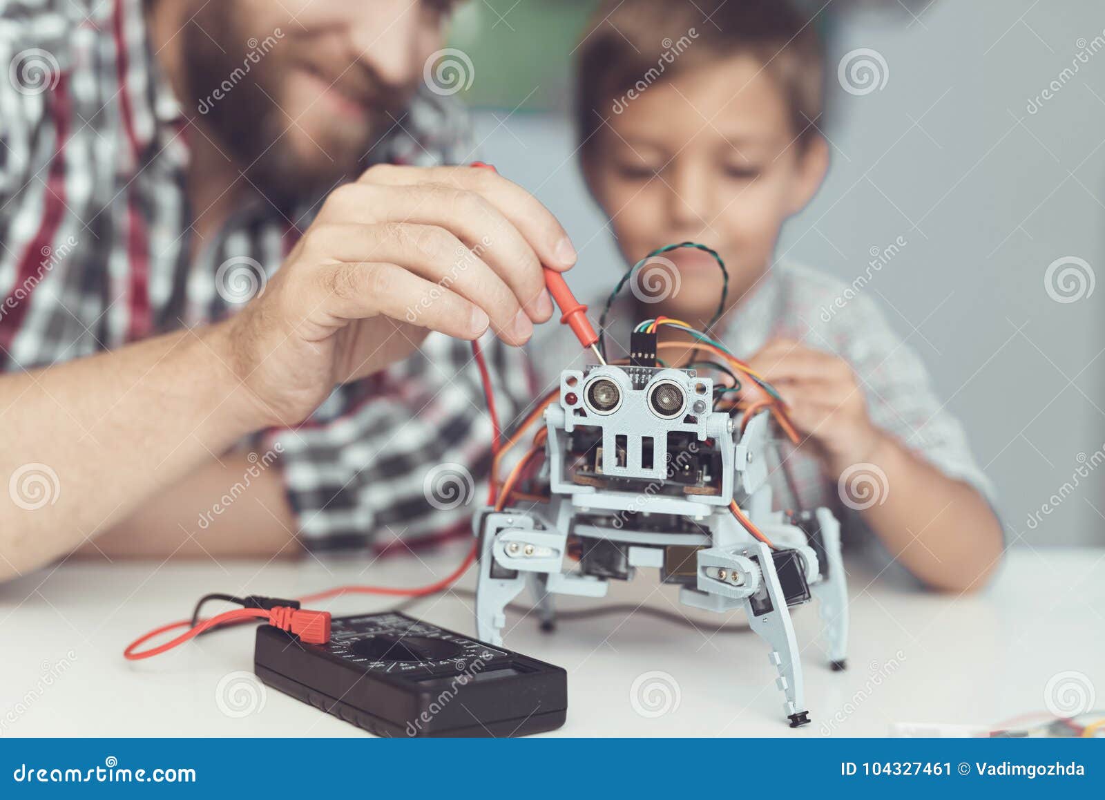 The Man and the Little Boy Measure the Robot`s Performance. they Use a ...