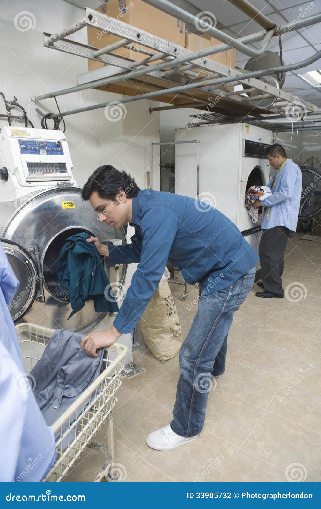 Men Loading Clothes in Washing Machine at Laundry Stock Photo - Image ...