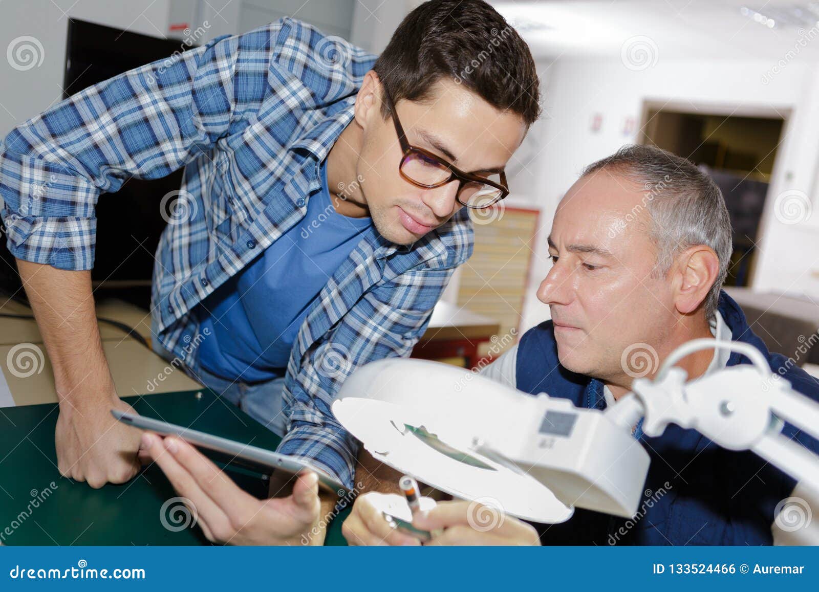 Men Looking at Object through Magnifier and Holding Tablet Stock Photo ...