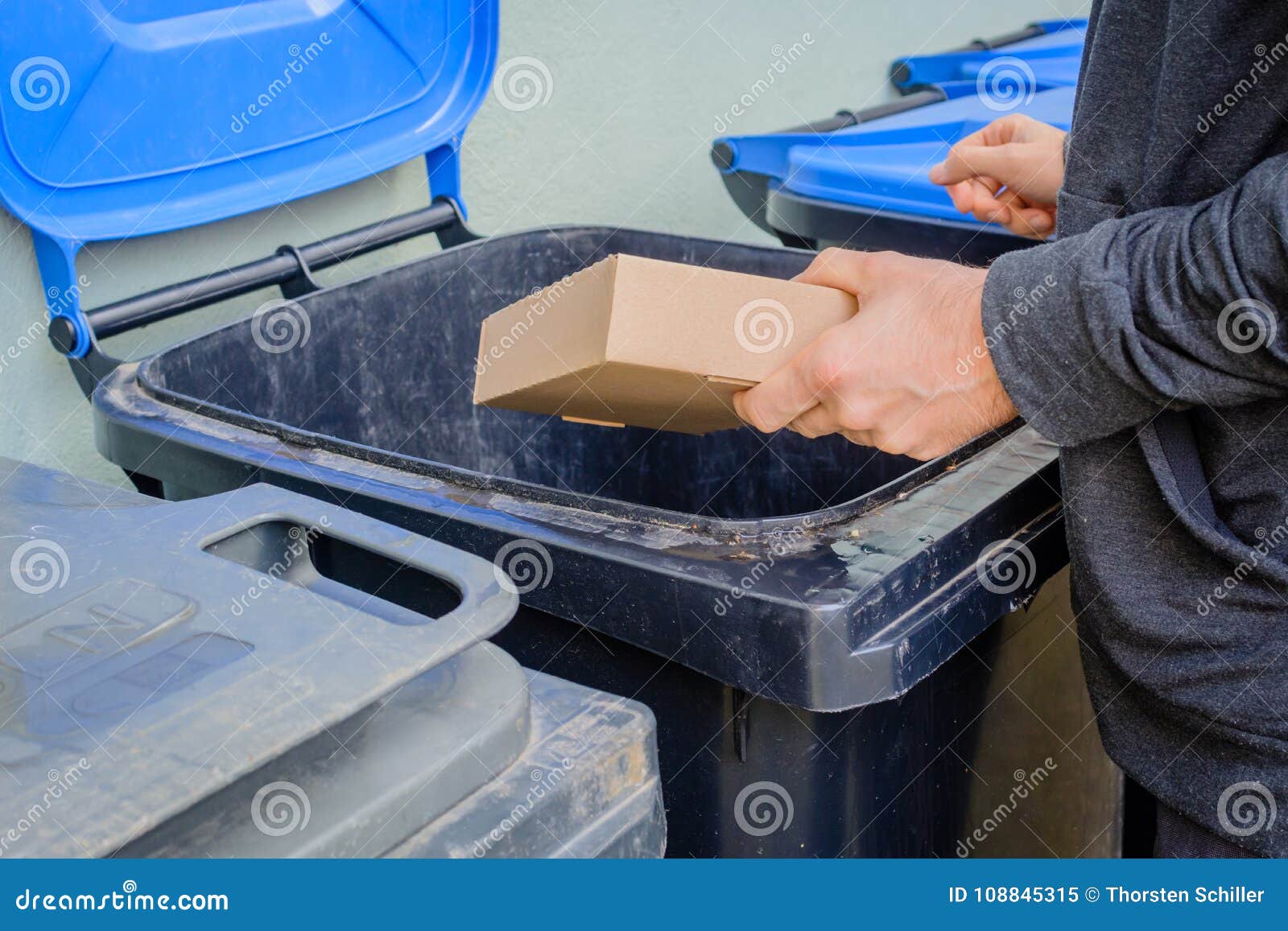 Men Putting Card Paper Box in Blue Garbage Container Stock Image ...