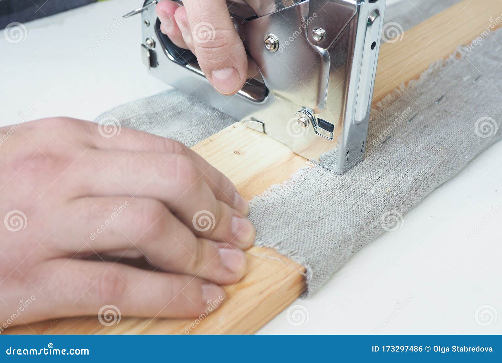 Men`s Hands are Wrapped in Rough Board with a Construction Stapler ...