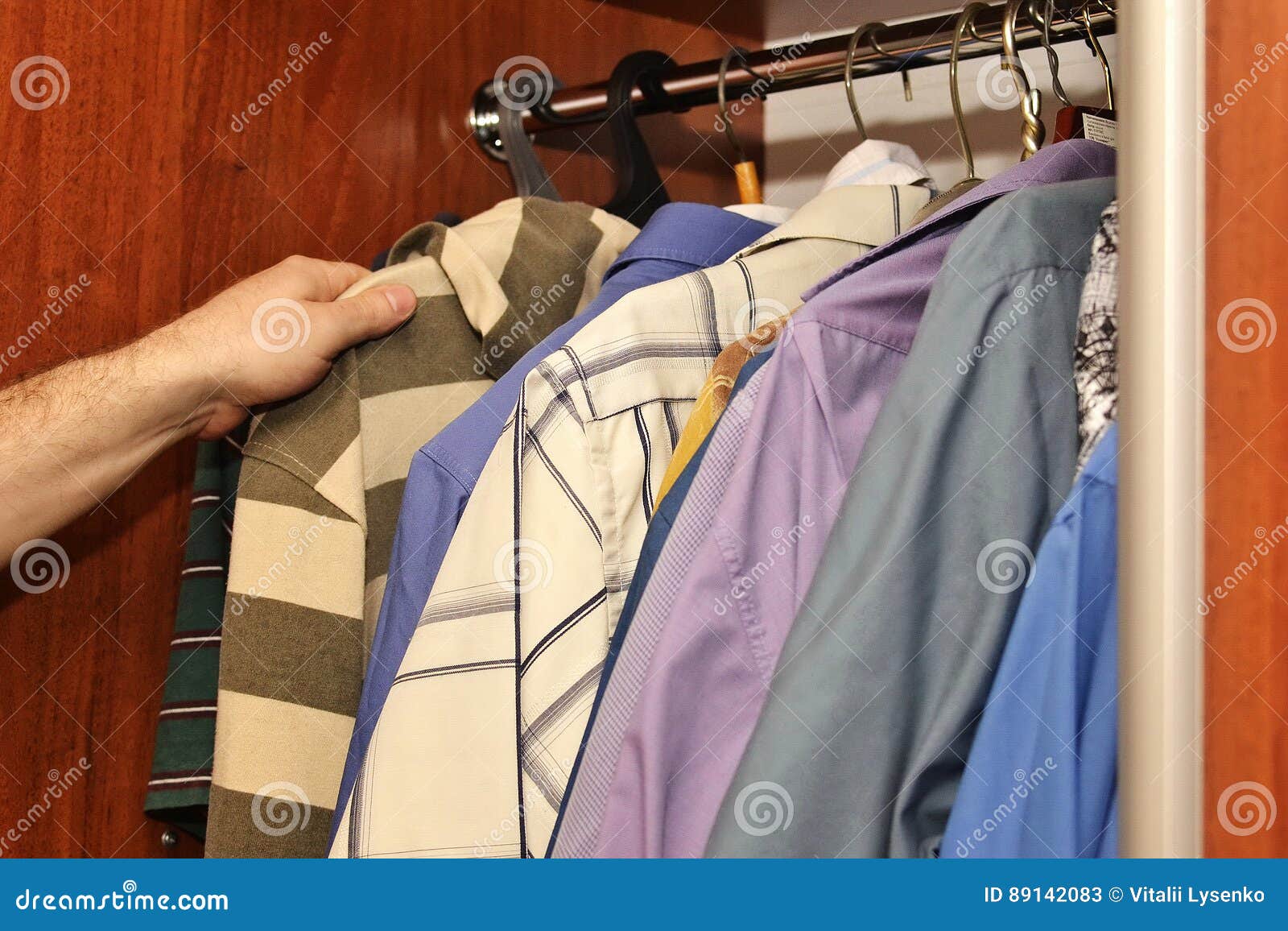 Male Hand Hangs Clothes on a Hanger in a Closet Stock Image - Image of ...