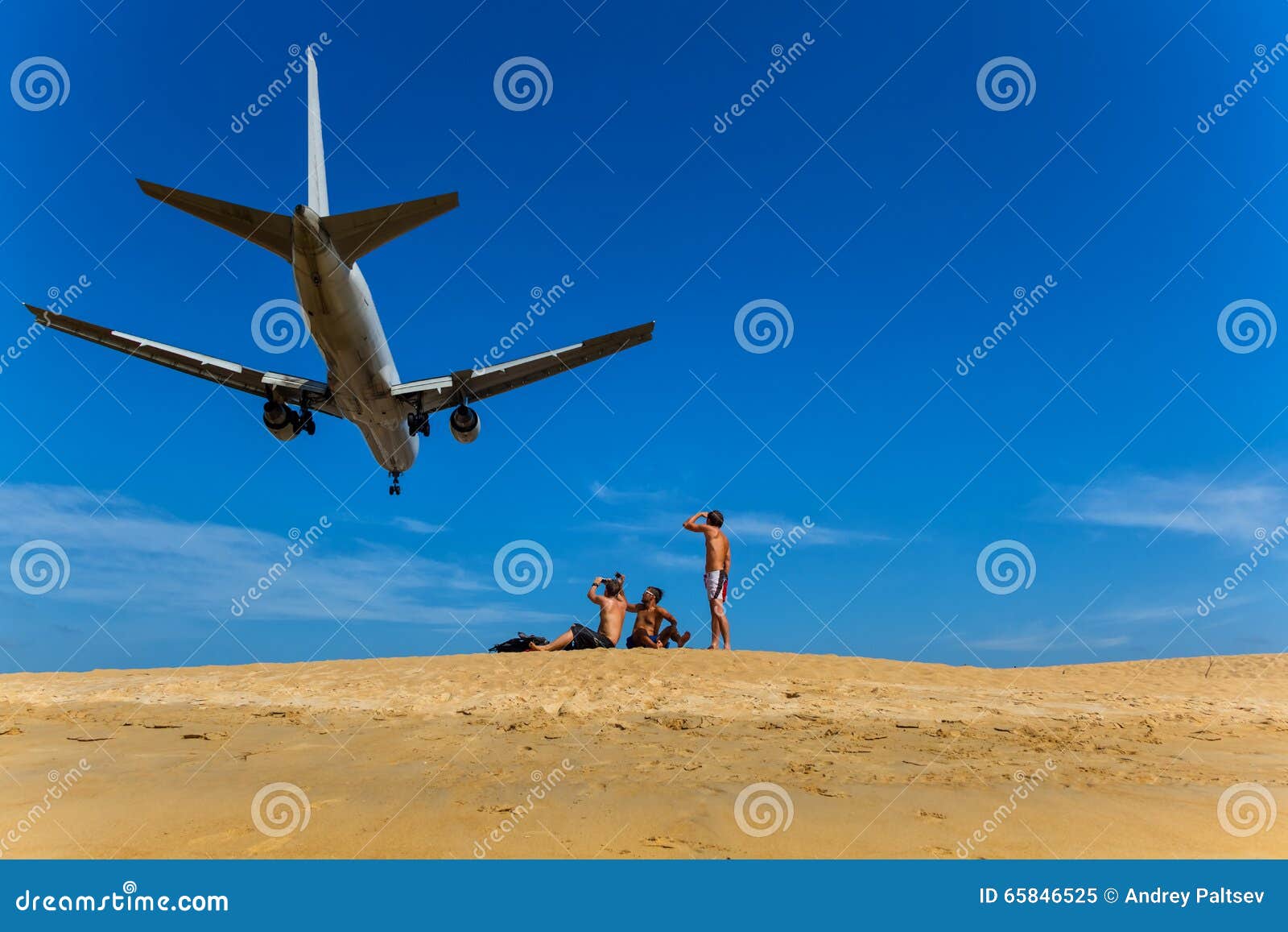 Men Sit on the Beach and Look at Them on a Plane Flying Over on Stock ...