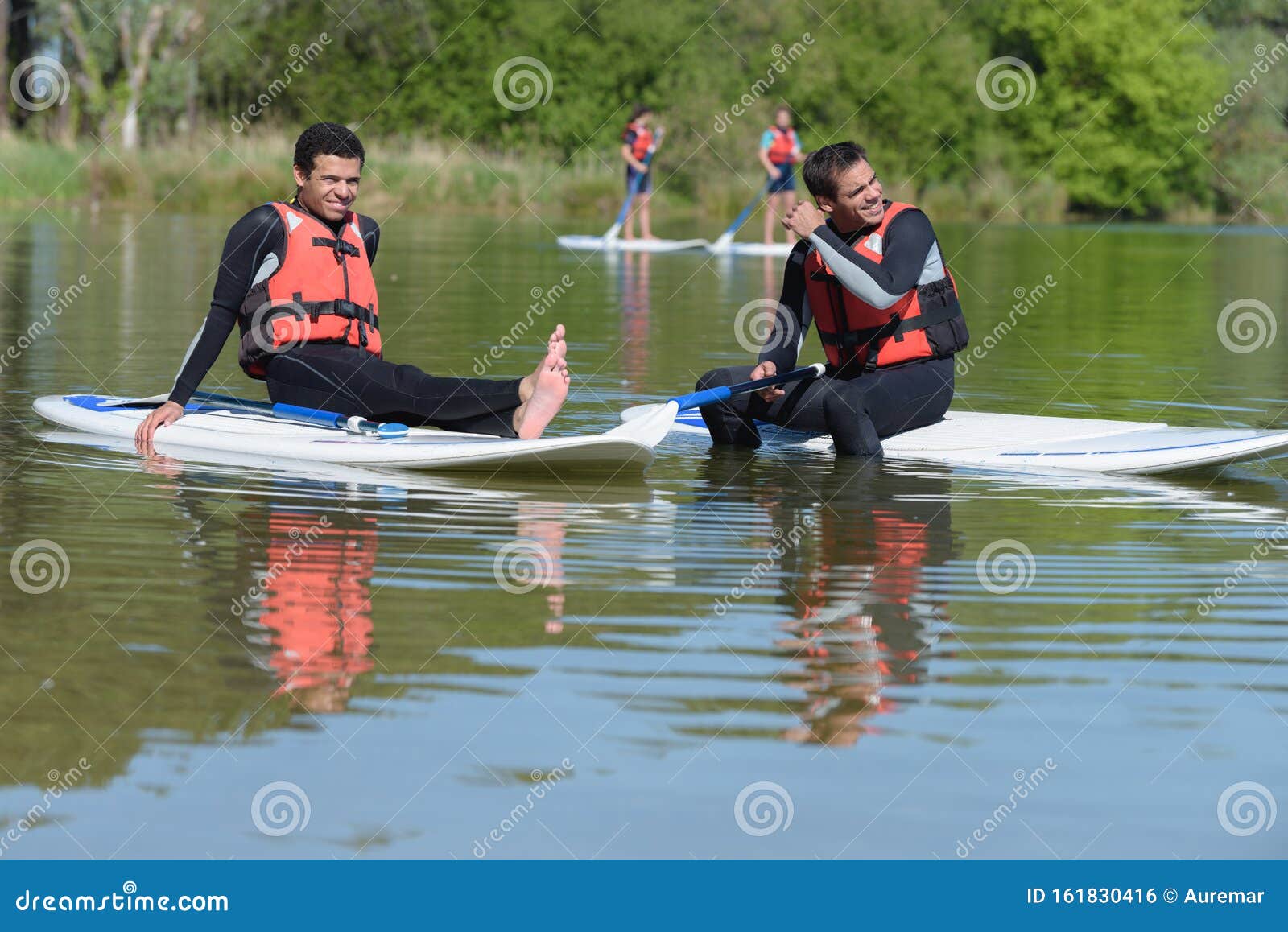 Men Sitting on Their Paddleboard Stock Photo - Image of contradictory ...
