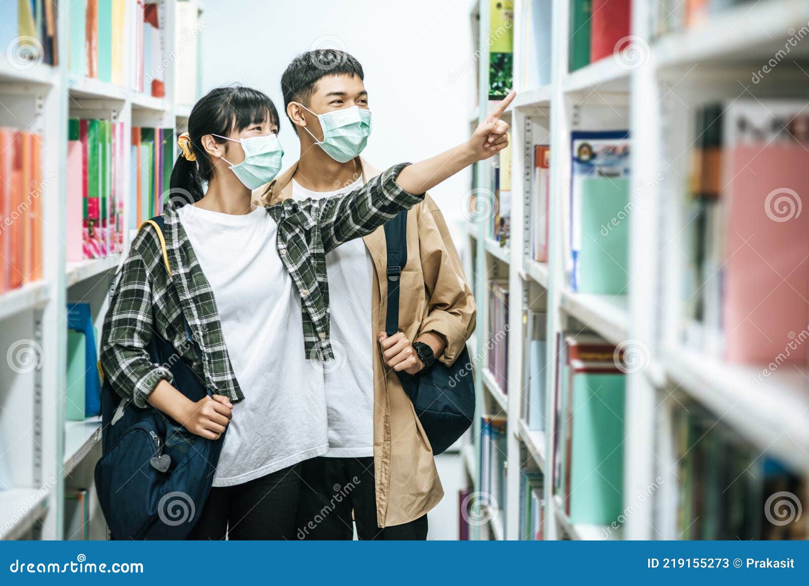 Men and Women Carrying a Backpack and Searching for Books in the ...