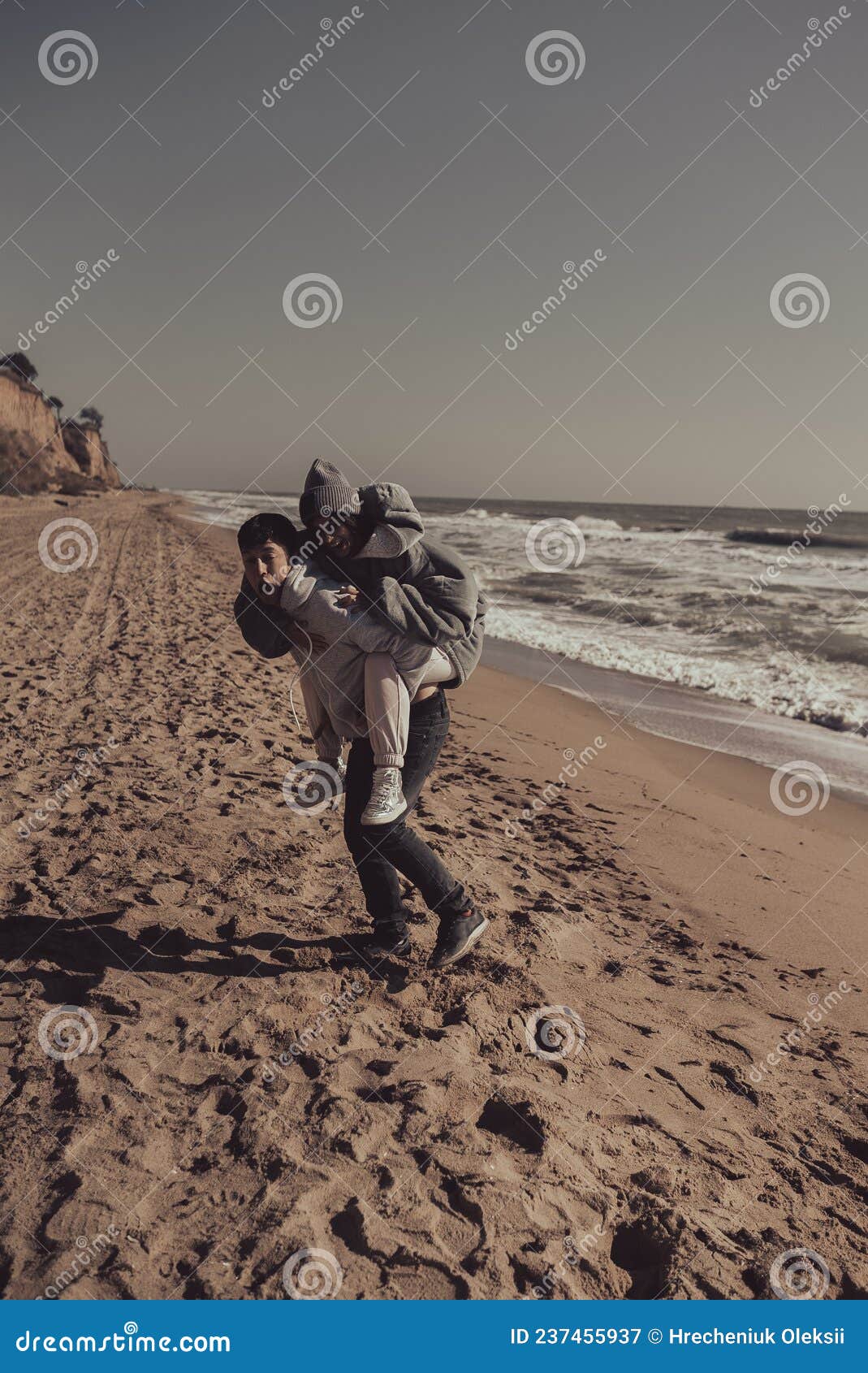 Man Carries His Girlfriend On Back Couple Having Fun On The Seashore