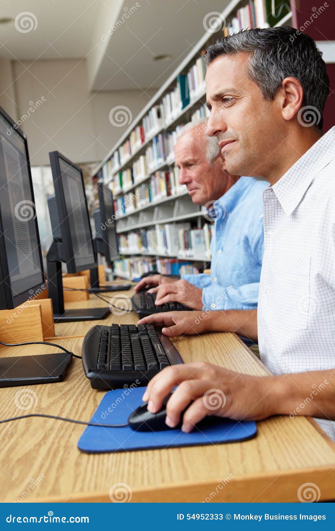 Men Working on Computers in Library Stock Image - Image of older ...