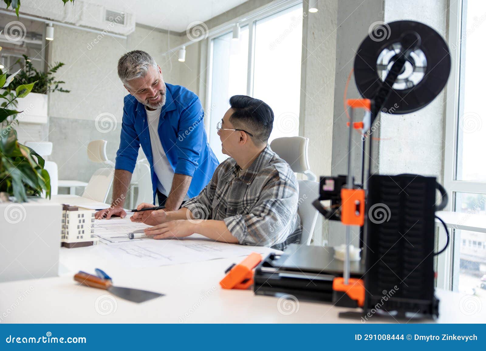 Men Working with 3D Printer and Blueprint for Designing Mechanical Parts in High Tech Workshop ...