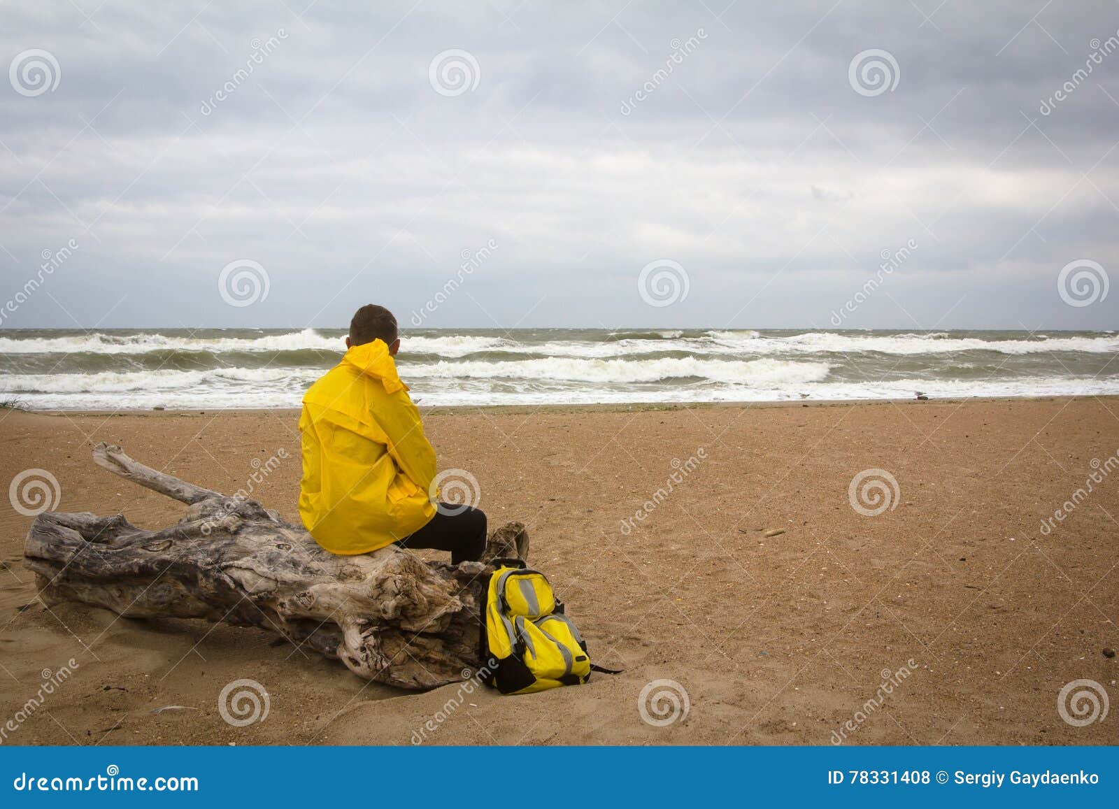 Men in Yellow Raincoat on the Beach Looking at Storm. Stock Photo ...
