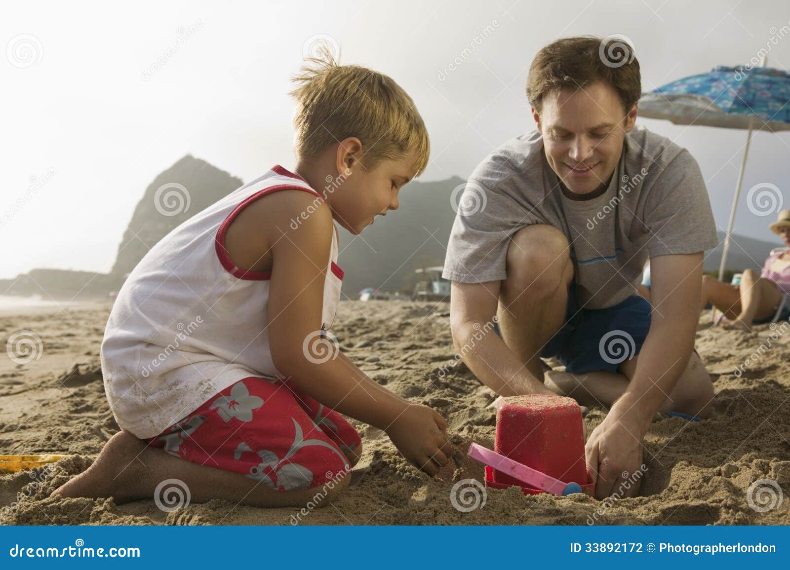 Menino E Pai Building Sand Castle Na Praia Foto de Stock - Imagem de ...