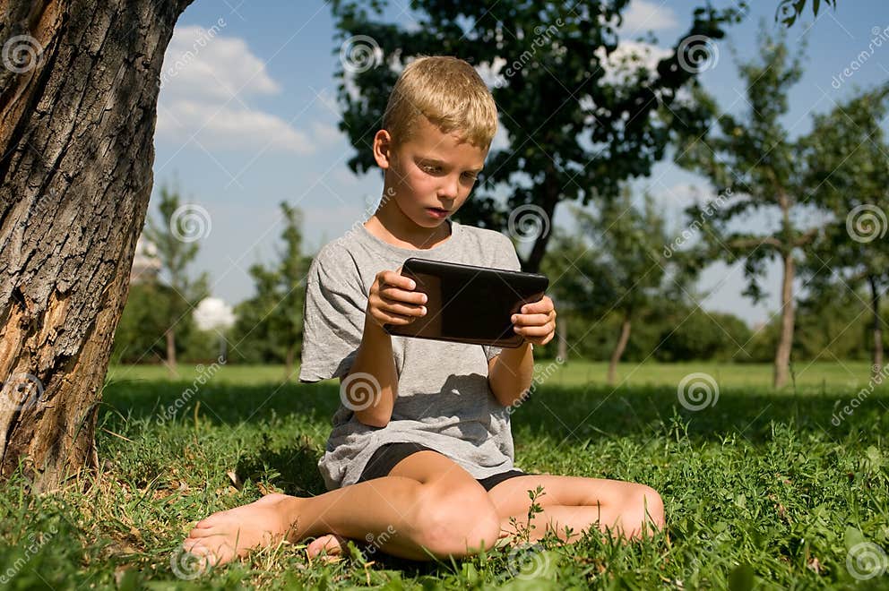 Menino Que Joga No Pc Da Tabuleta Foto De Stock Imagem De Computador