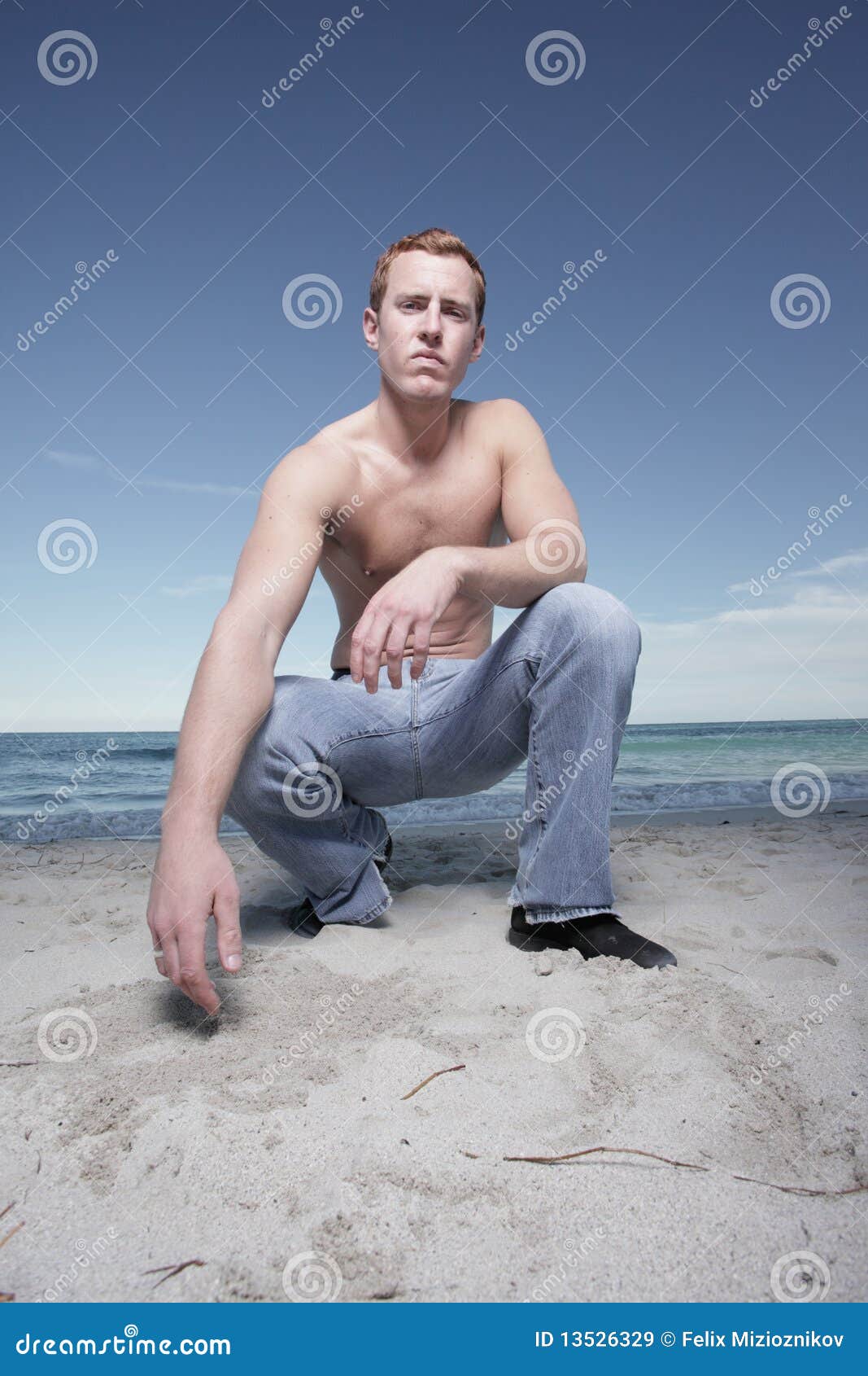 Mens die op het zand hurkt stock afbeelding. Image of exemplaar - 13526329