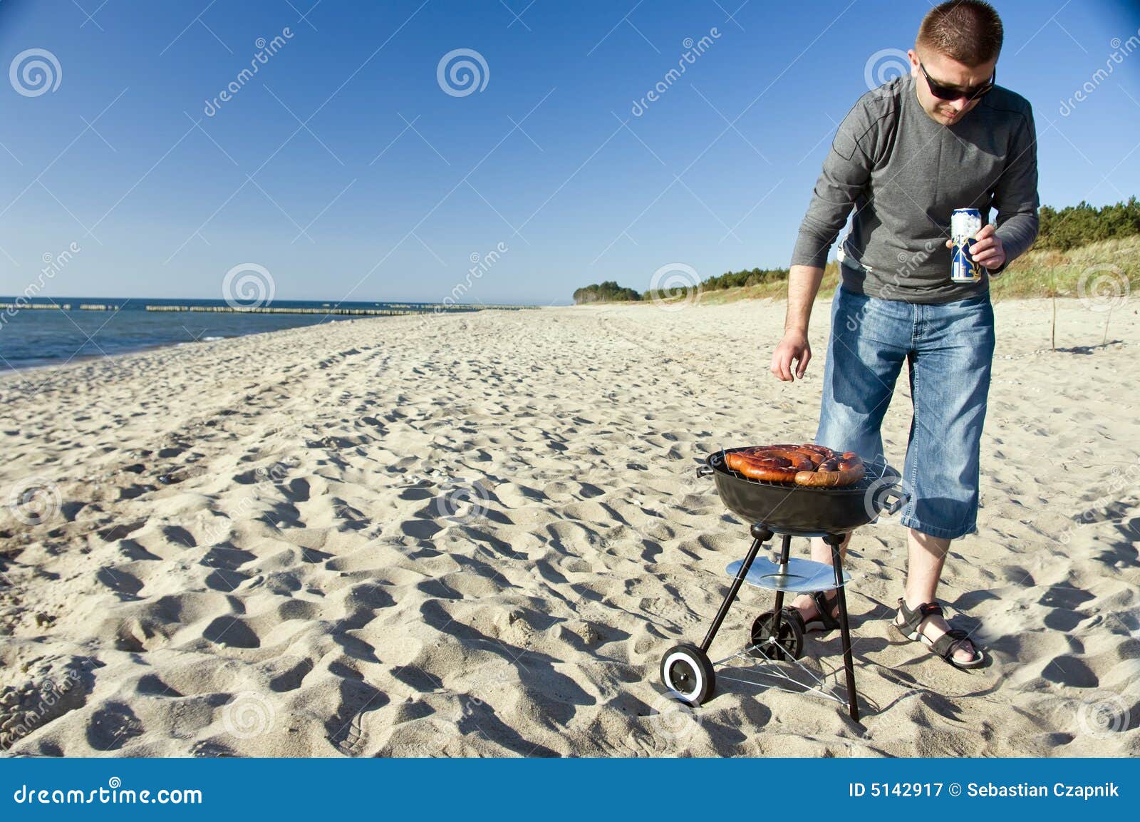 Mens en barbecue op strand stock afbeelding. Image of greep - 5142917
