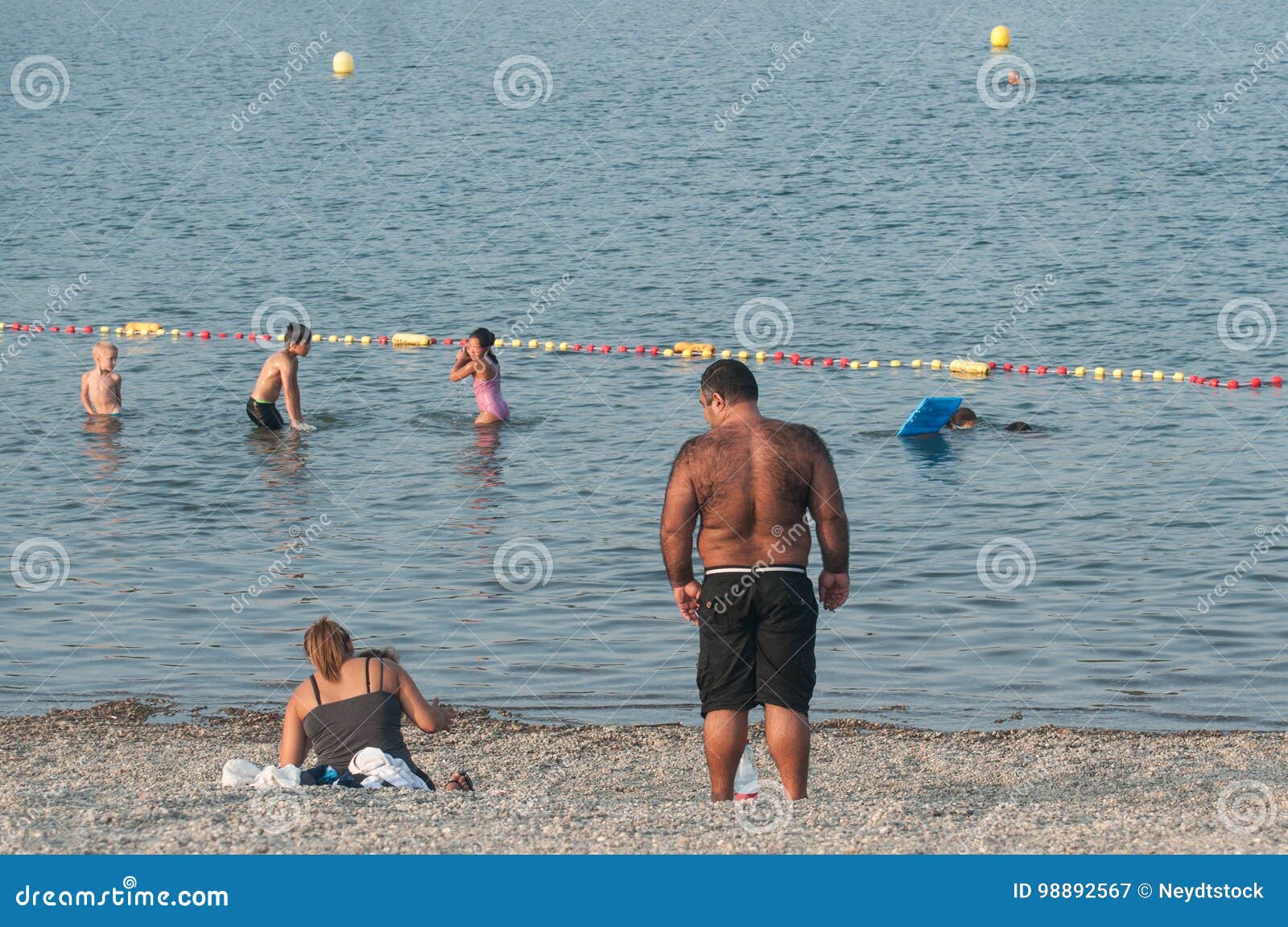 Mensen Op Het Strand Met De Harige Mens Redactionele Fotografie - Image of nave, leugen: 98892567