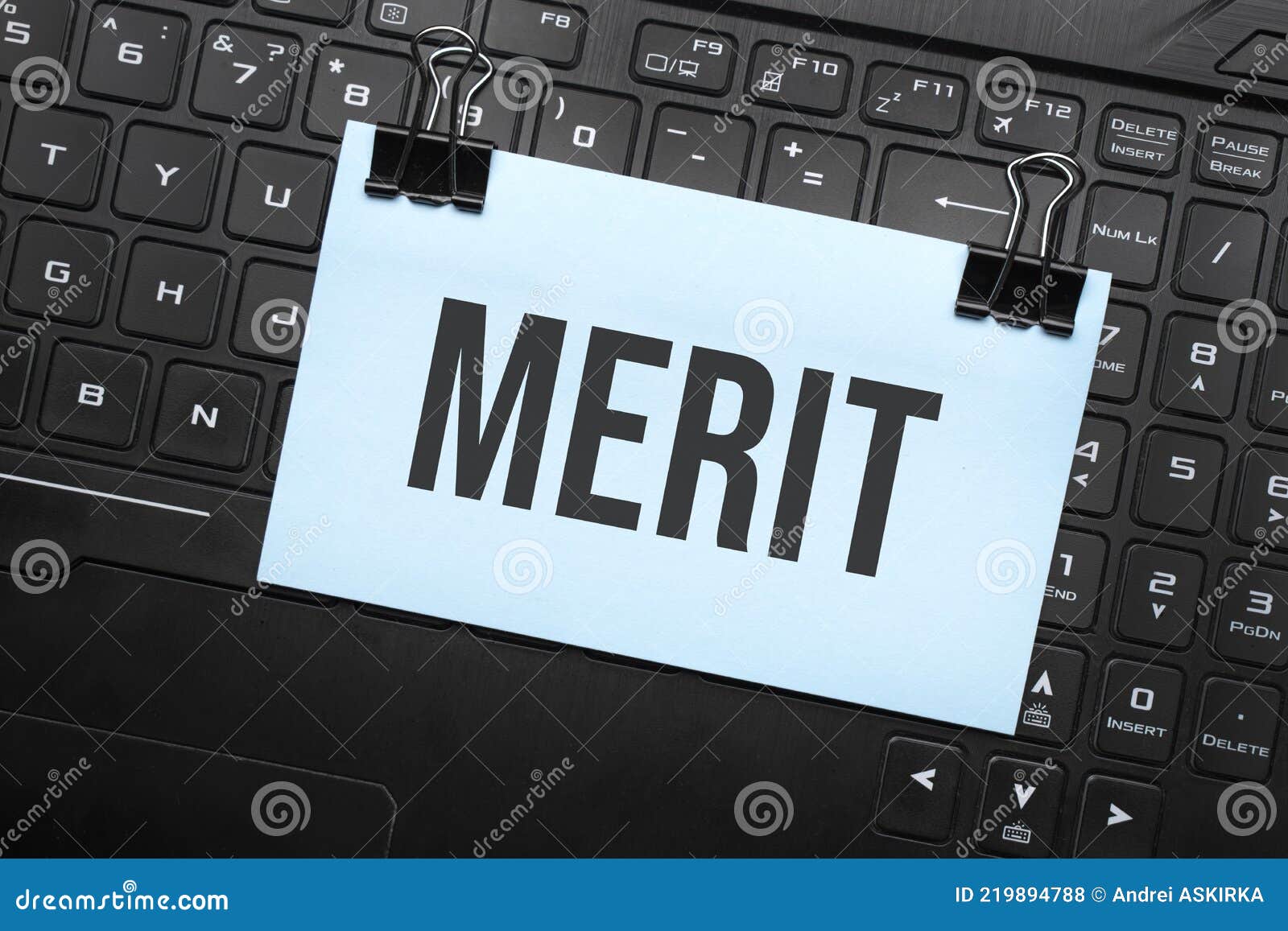 Merit Inscription on White Paper Note on Laptop Keyboard. Closeup ...
