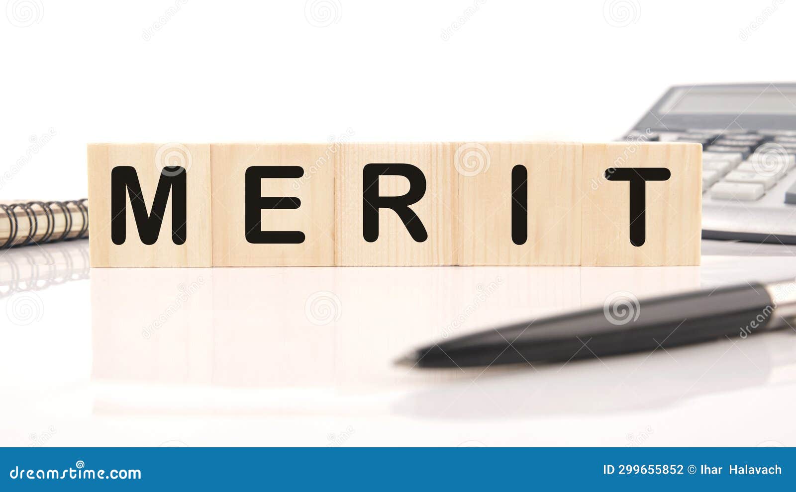 Merit Word Assembled from Wooden Cubes Next To a Calculator, Pen and ...