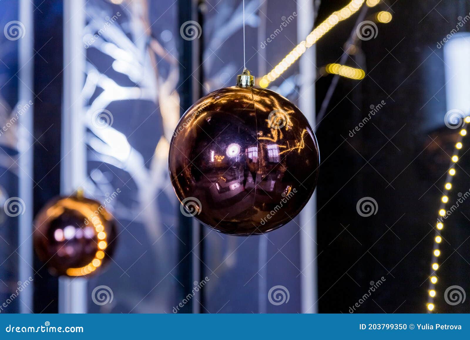 A Merry Christmas Ornaments Hanging In Front Of A Bokeh Background Of