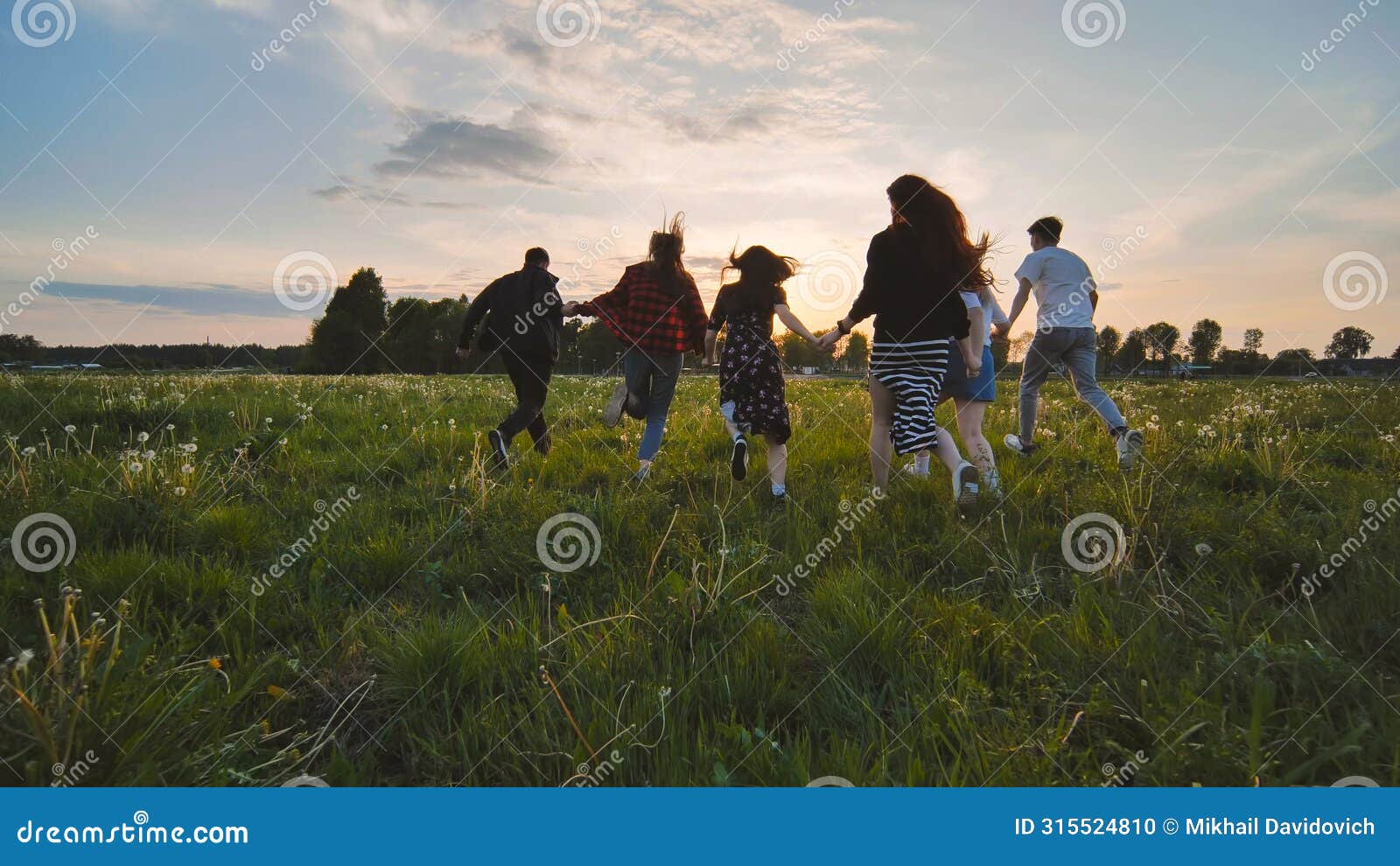 Merry Friends Run Off into the Sunset Holding Hands. Stock Photo ...