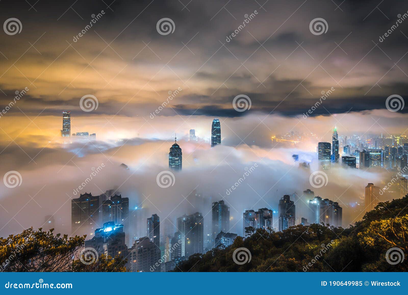 Mesmerizing Shot of the Skyscrapers of a City Covered in Mist at Night ...