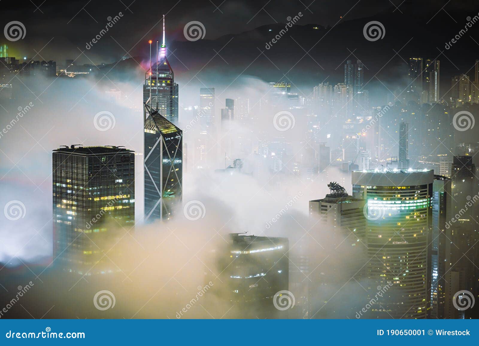 Mesmerizing Shot of the Skyscrapers of a City Covered in Mist at Night ...
