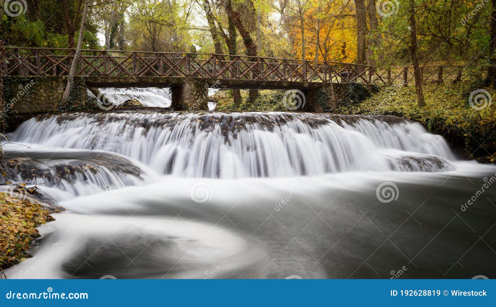 Mesmerizing View of a Bridge Over the Beautiful Waterfall in the Middle ...