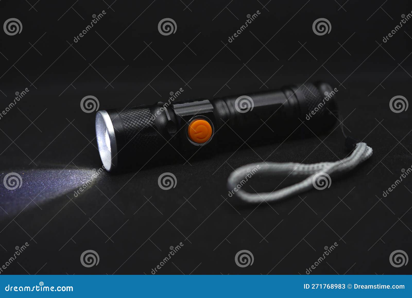 Metal Black Flashlight on a Black Background. Burning Pocket Flashlight ...