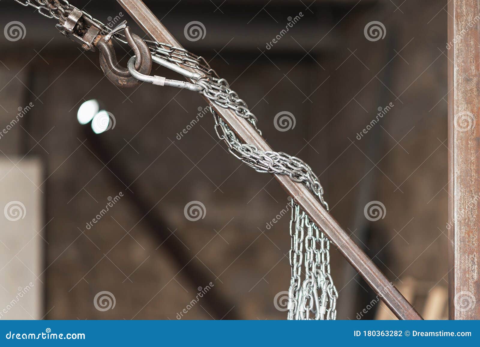Metal Chains in a Workshop Hang from a Rusty Metal Pipe Stock Photo ...