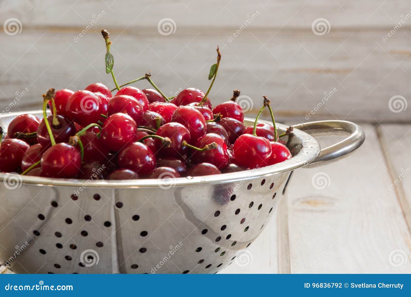 Metal Colander Full of Freshly Cherries Over a Rustic Board. Cherry ...