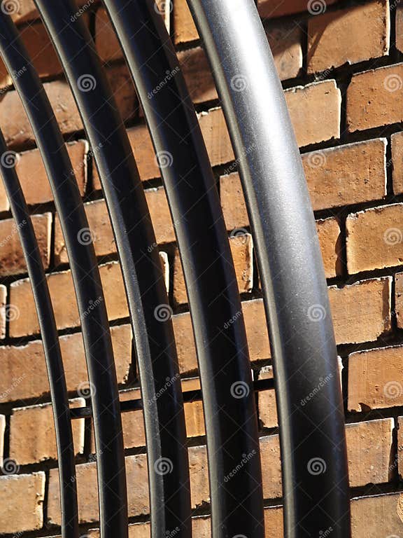 Metal Constructions and Brick Wall Stock Photo - Image of shiny, curved ...