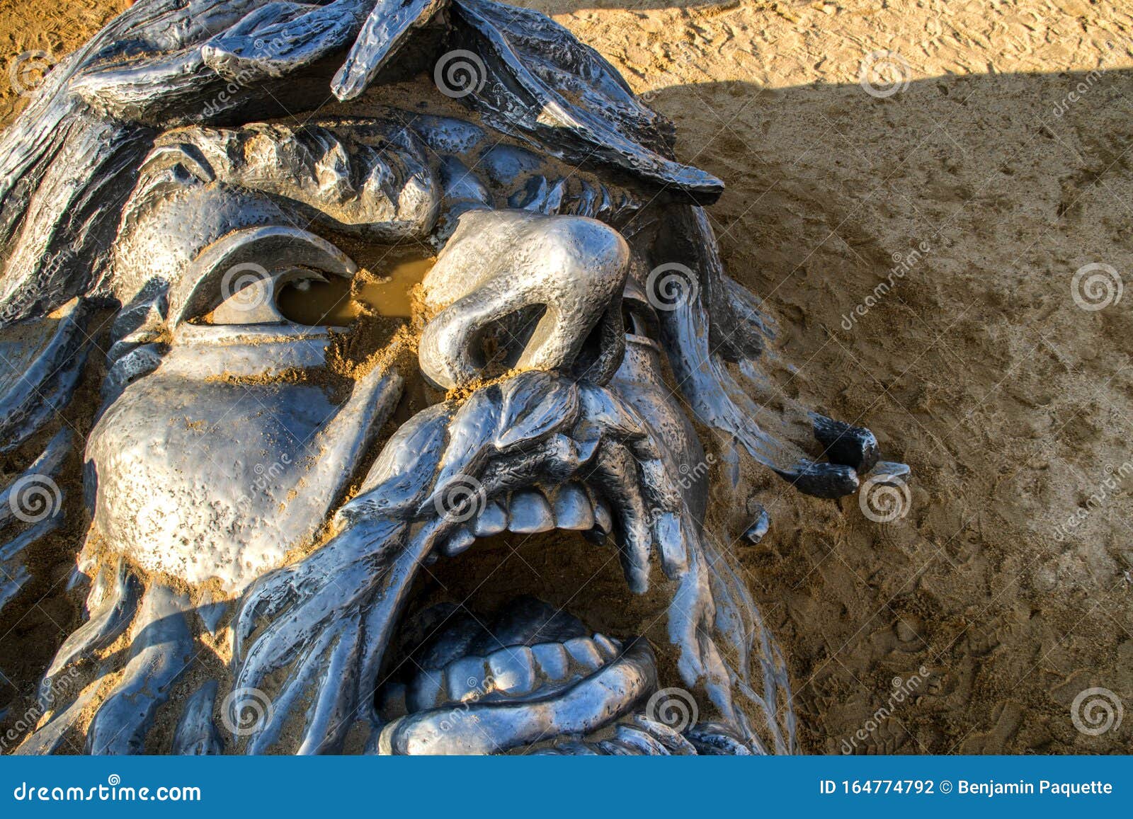 Metal Face Sculpture in the Sand by the Ocean Editorial Photography ...