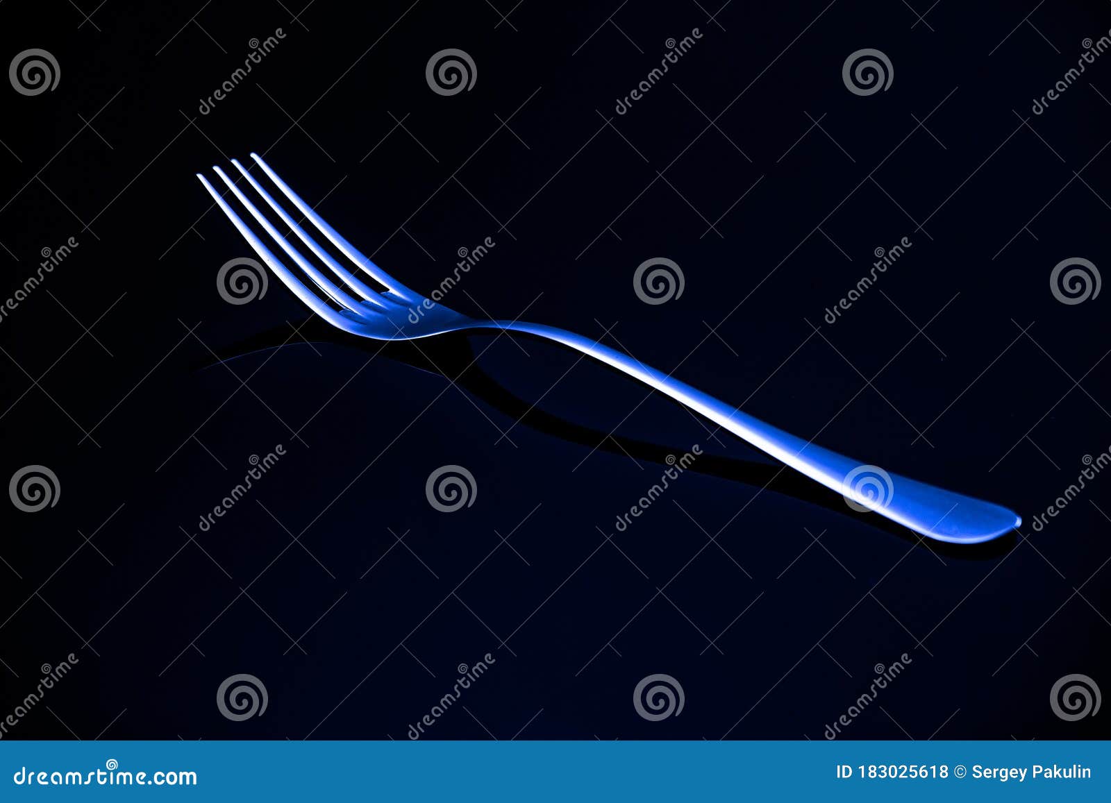 A Metal Fork with a Blue Neon Reflection Rests on a Black Glass ...