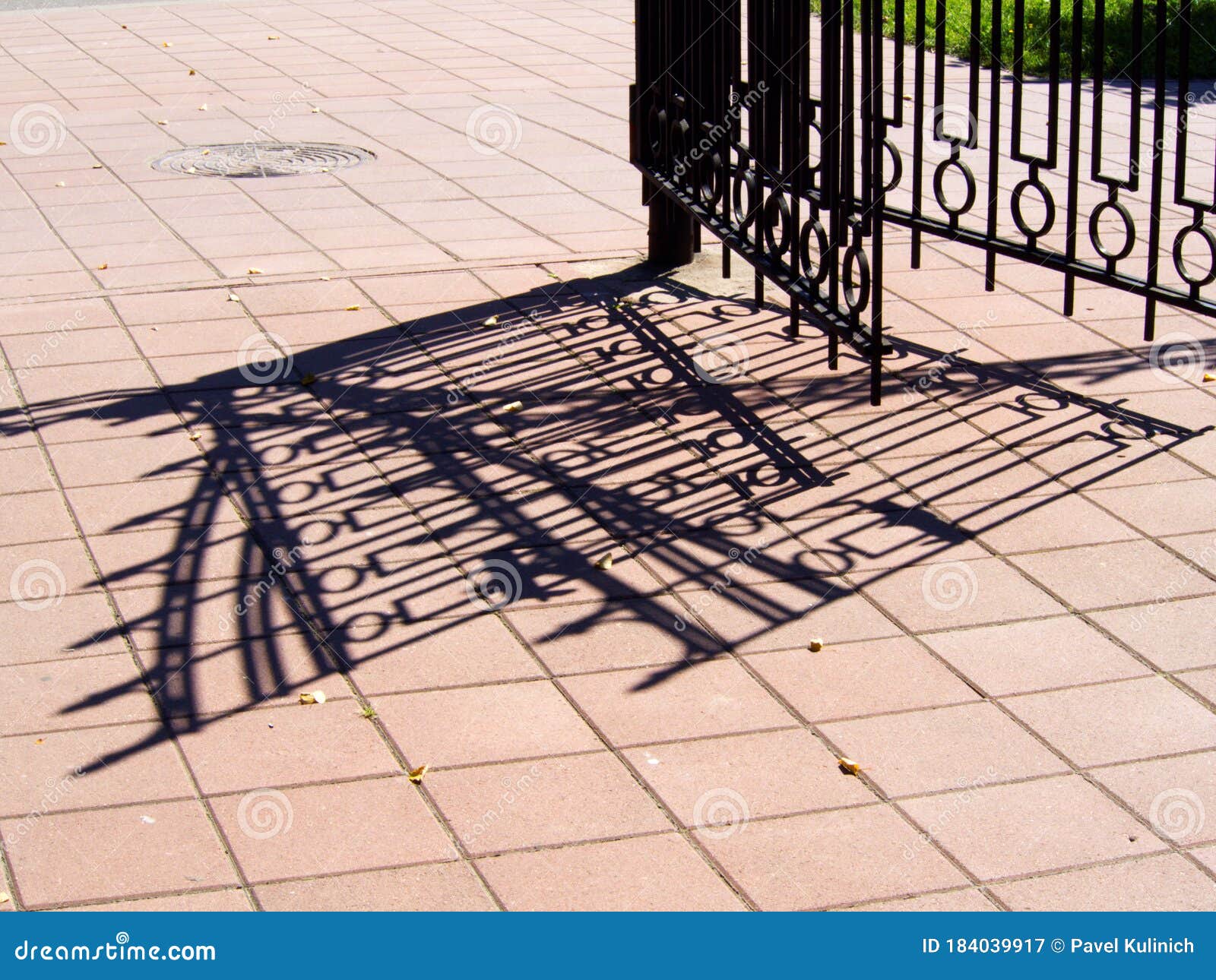 Metal Gate and Fence and Its Shadow on the Pavement Stock Image - Image ...