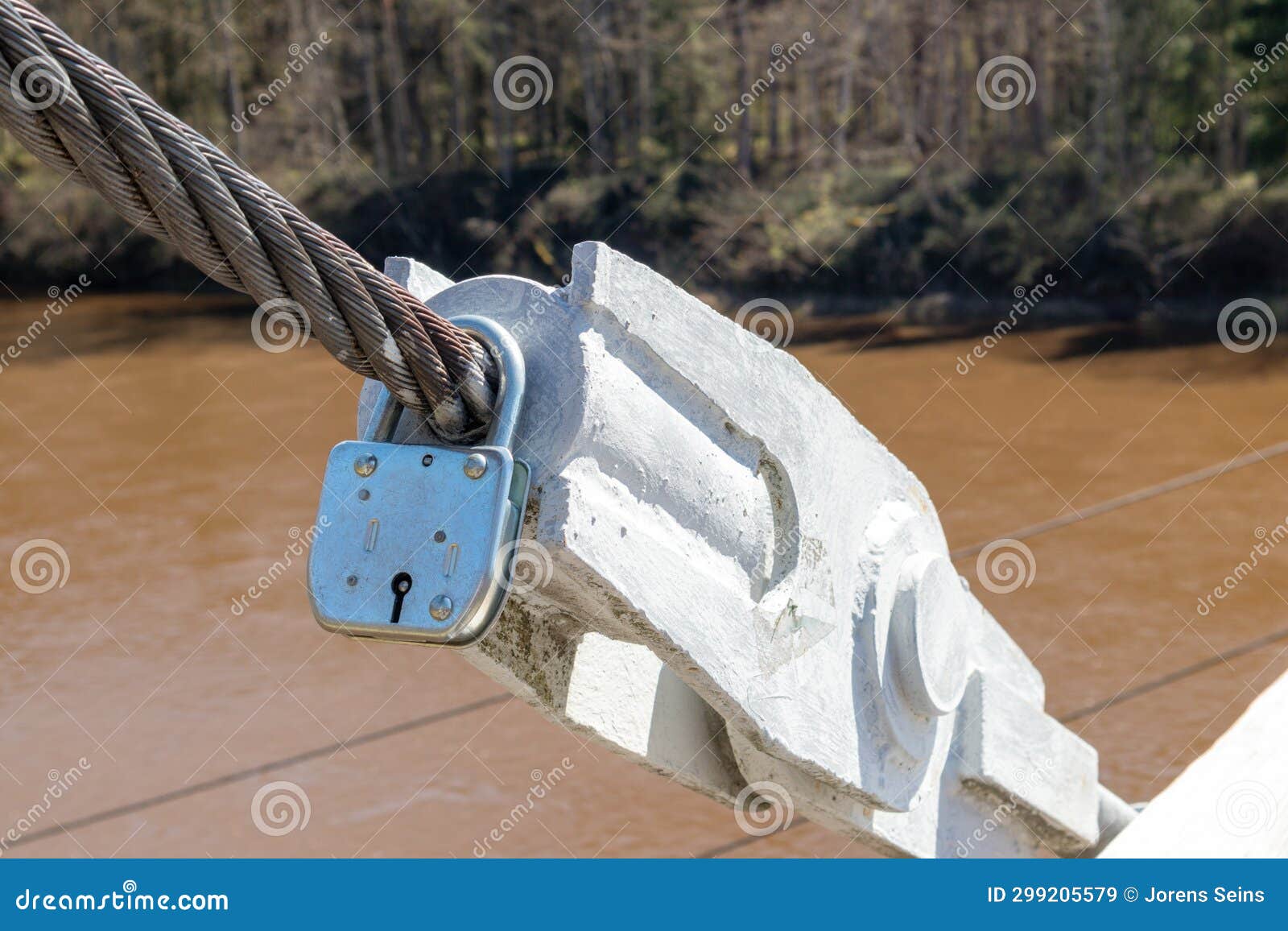 Metal Key Hooked and Locked on Metal Rope with River and Tree ...