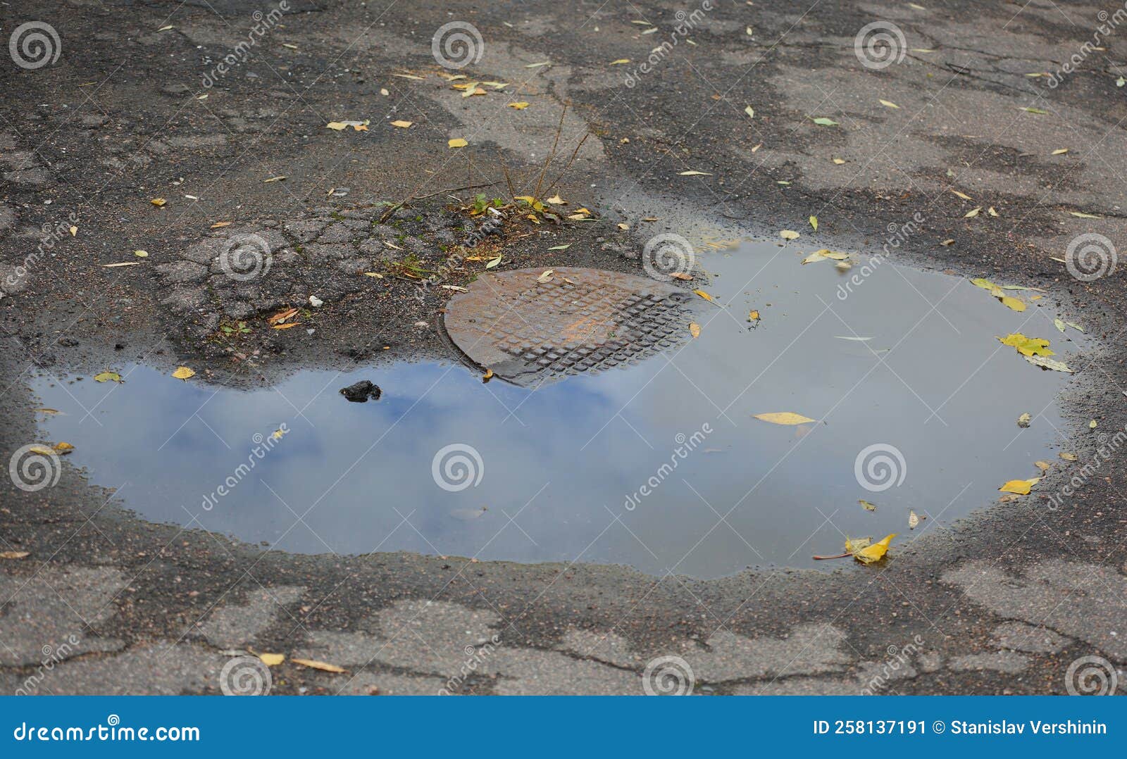 Metal Manhole Cover Half Hidden by a Puddle Stock Image - Image of ...