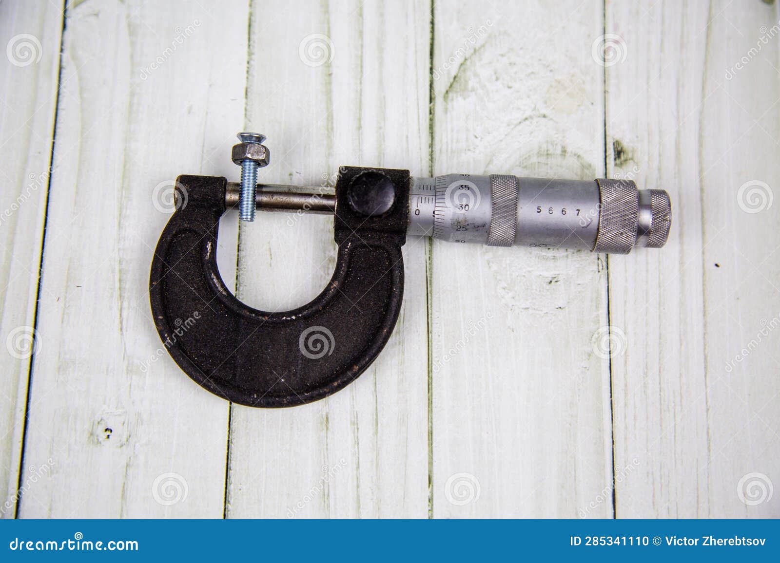 A Metal Micrometer with Nuts and Bolts on a Gray Wooden Table. Stock ...