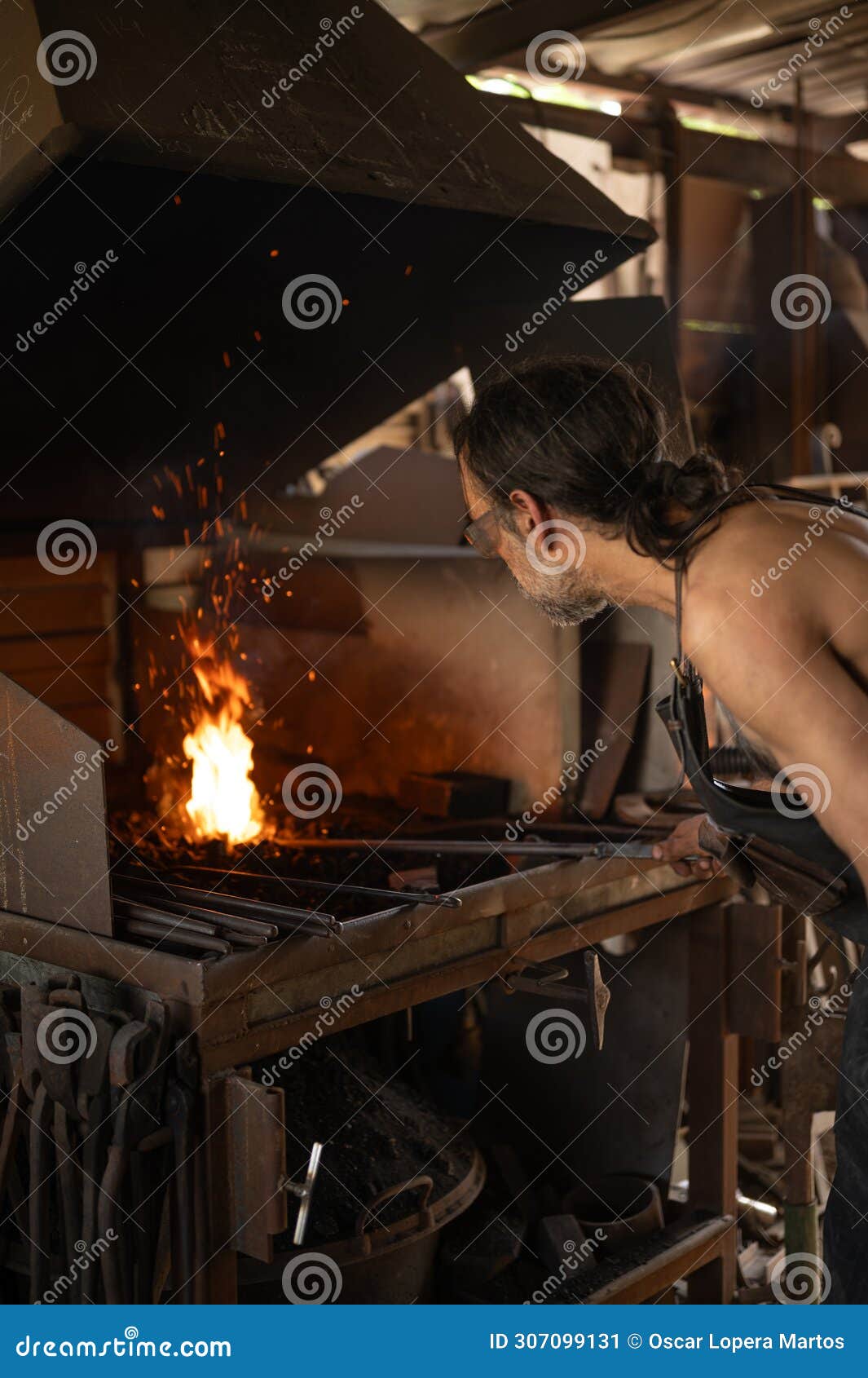 Metalworker Stoking the Fire in a Forge To Work Steel. Stock Image ...