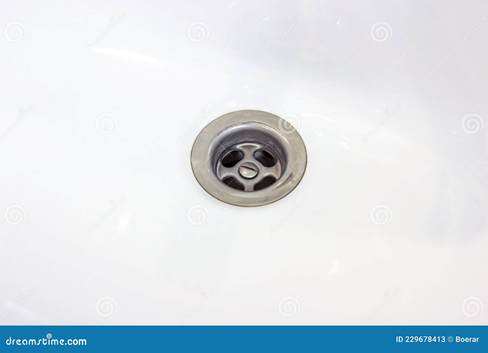 Metallic Water Drain Hole In The White Ceramic Sink In The Bathroom