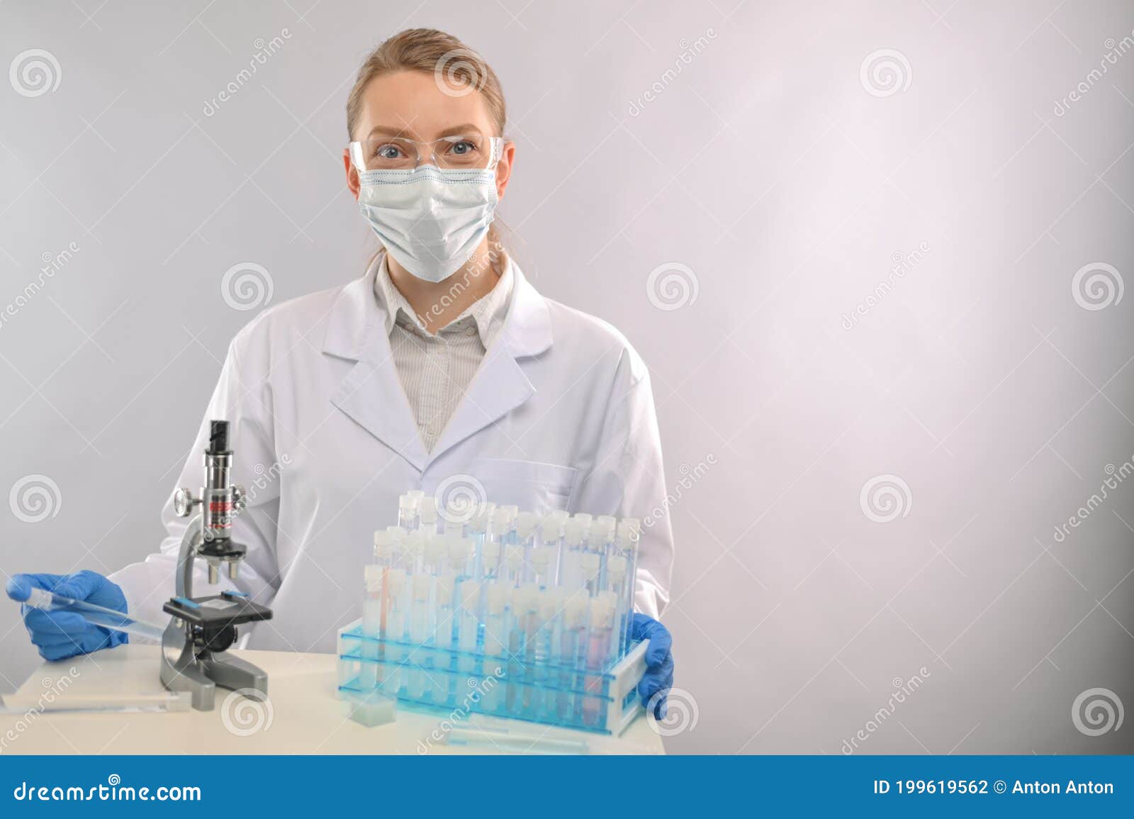 Microbiologist in Biohazard Protective Clothing Siting at the Table ...