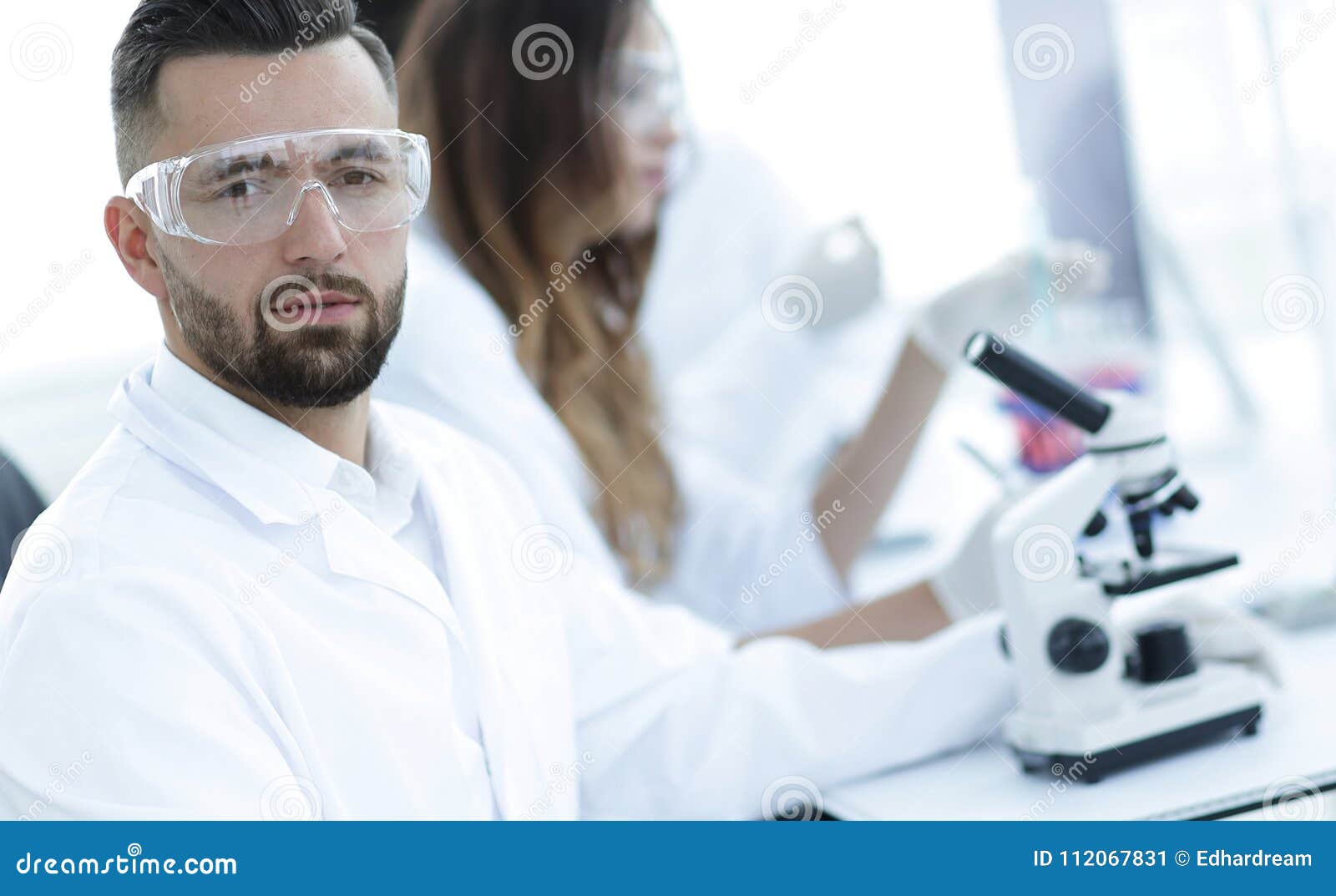 Microbiologist and His Colleagues are Sitting in a Modern Laboratory ...