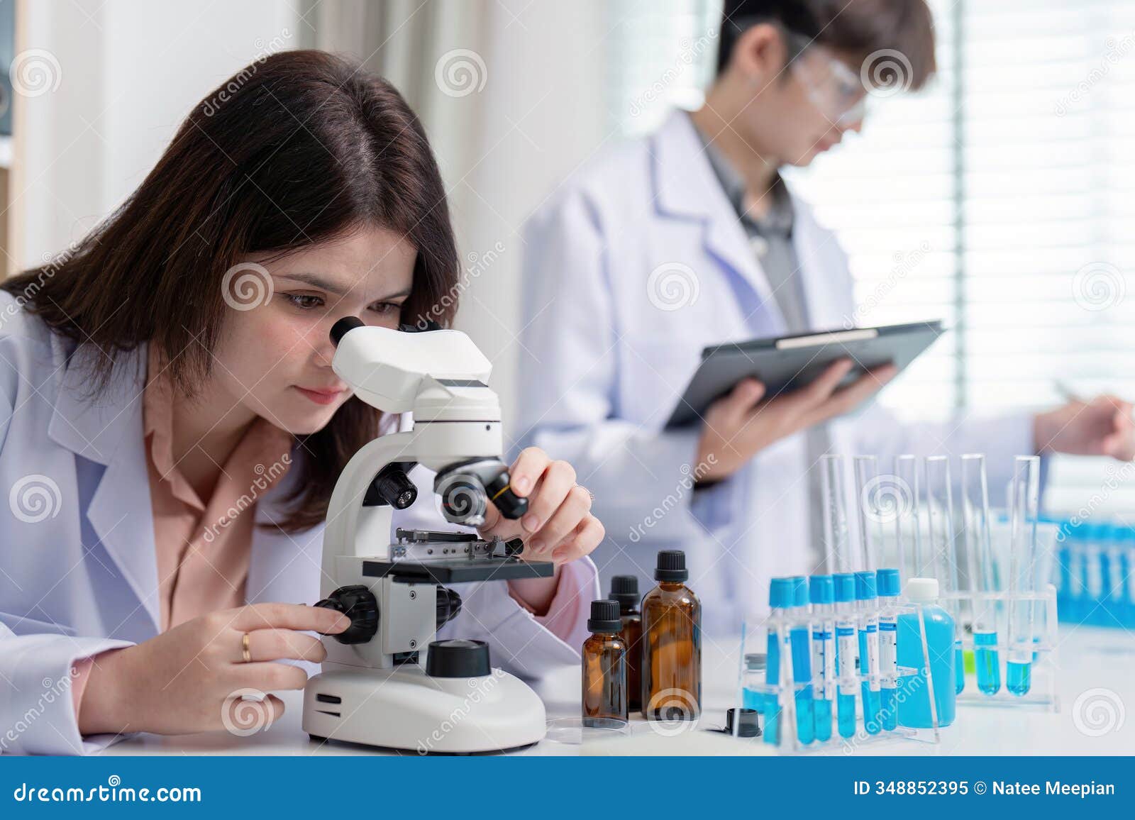Microbiologist Using Microscope for Research in Modern Lab Setting ...