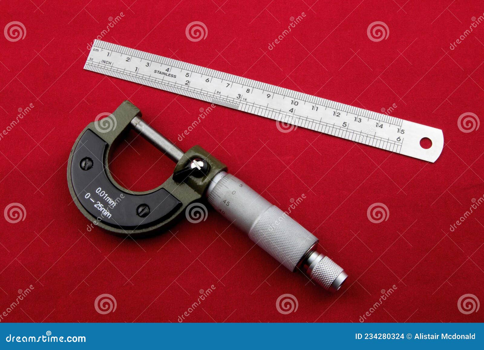Engineering Micrometer and Steel Ruler on a Red Table Surface Stock ...