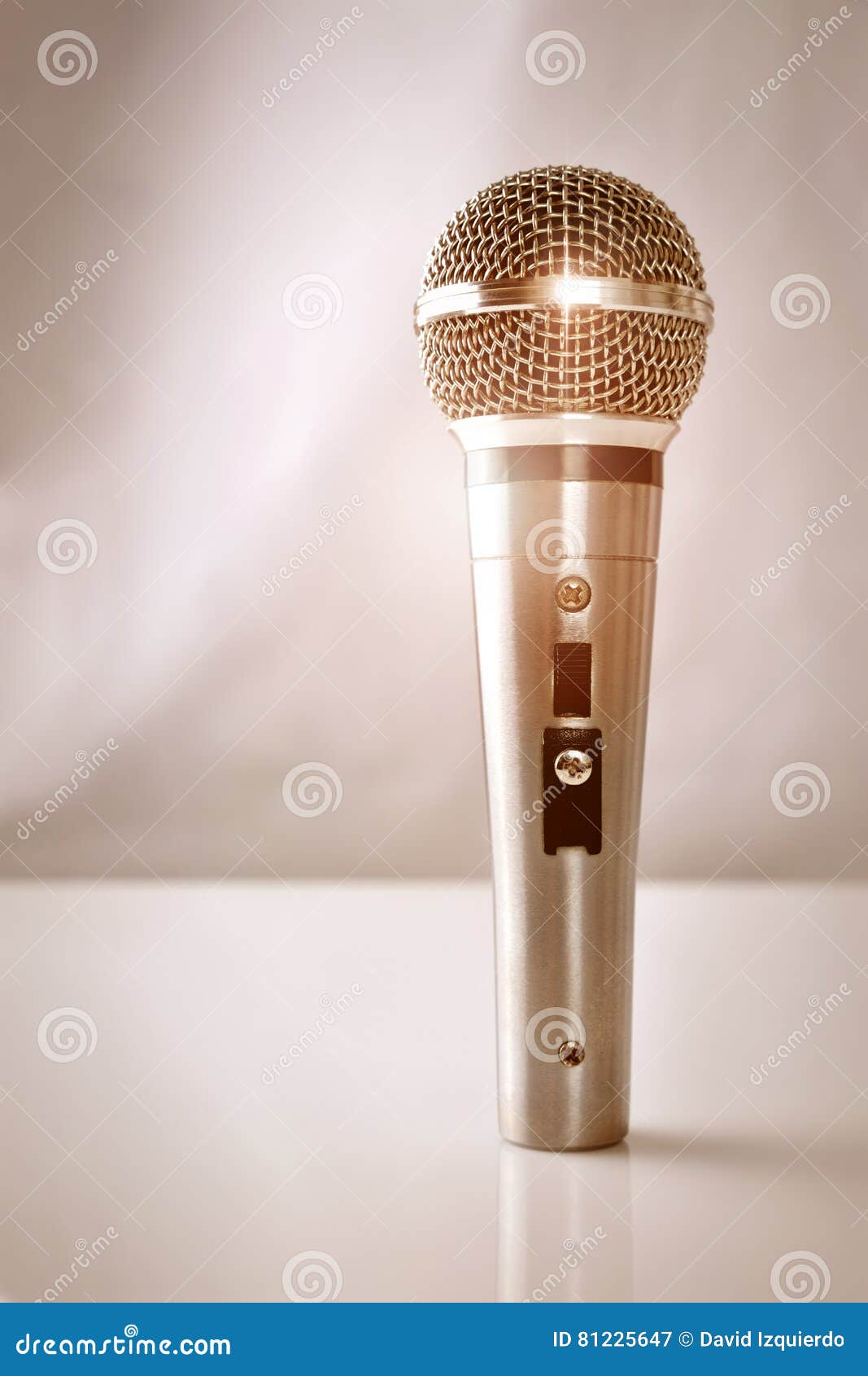 Microphone with Golden Reflections Standing on a White Glass Stock ...