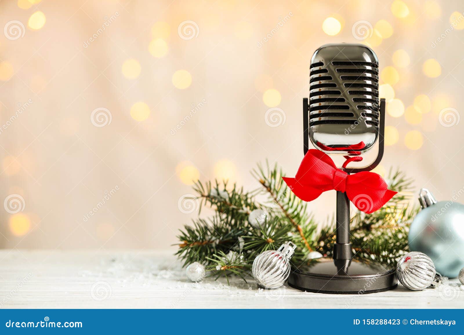 Microphone with Red Bow and Decorations on White Table Against Blurred ...