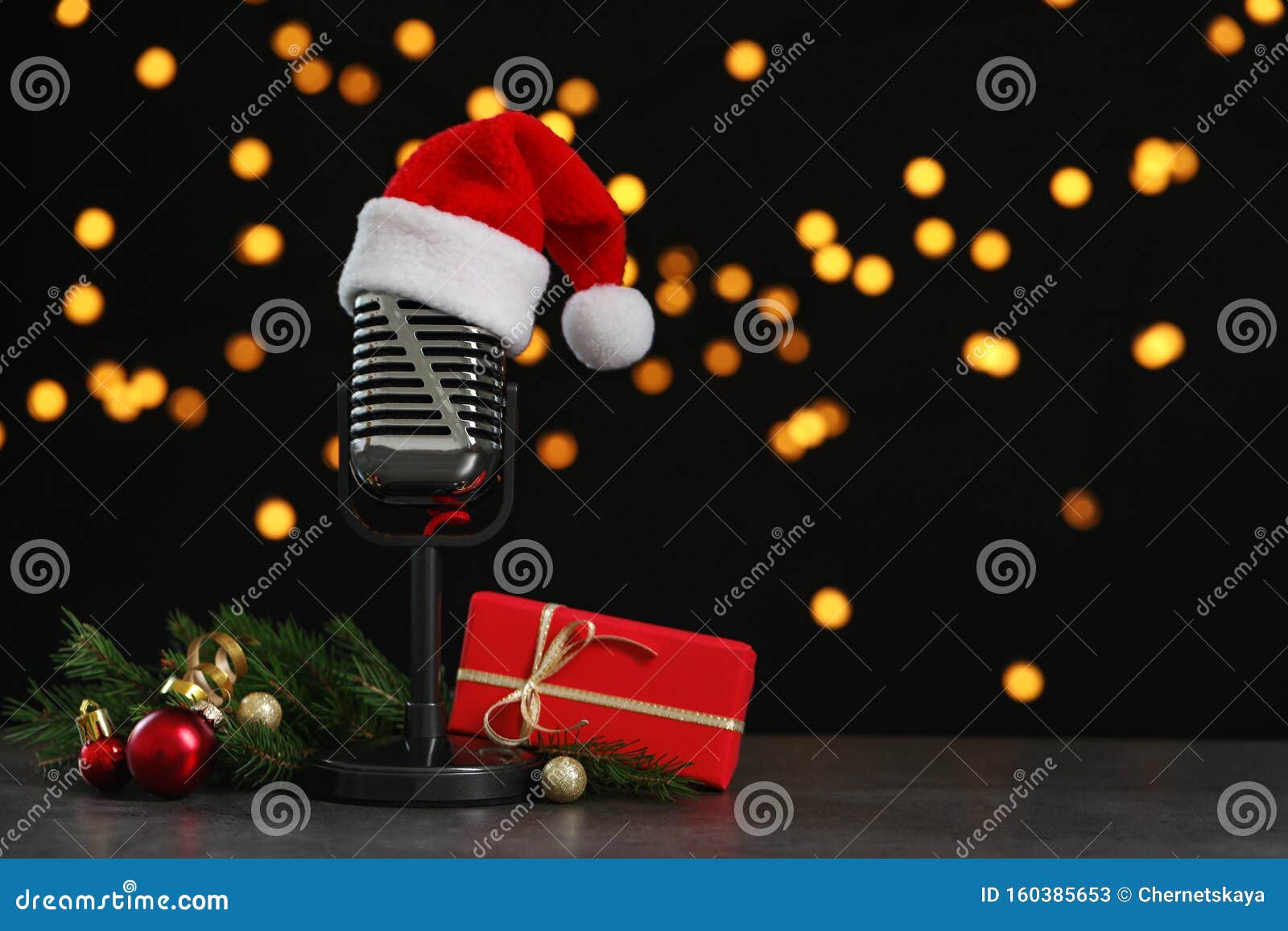 Microphone with Santa Hat and Decorations on Table Against Blurred ...