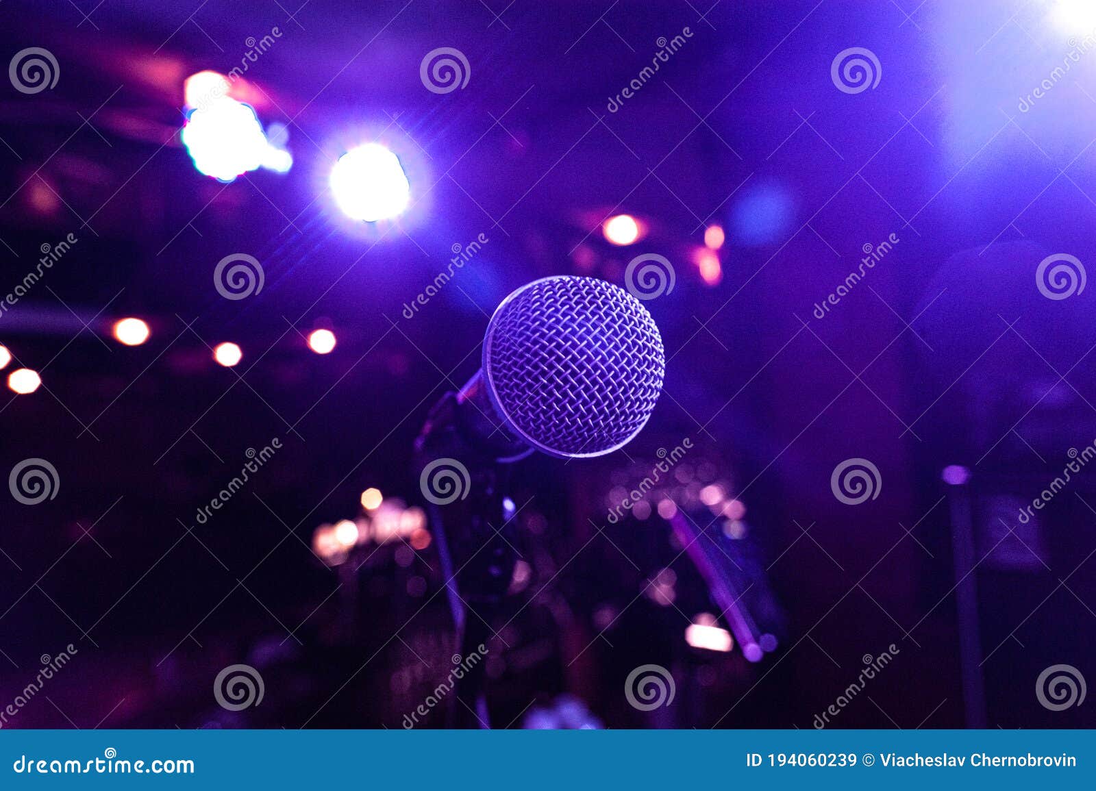 Microphone of a Star on a Stand in a Hall with Many Multicolored Lights ...