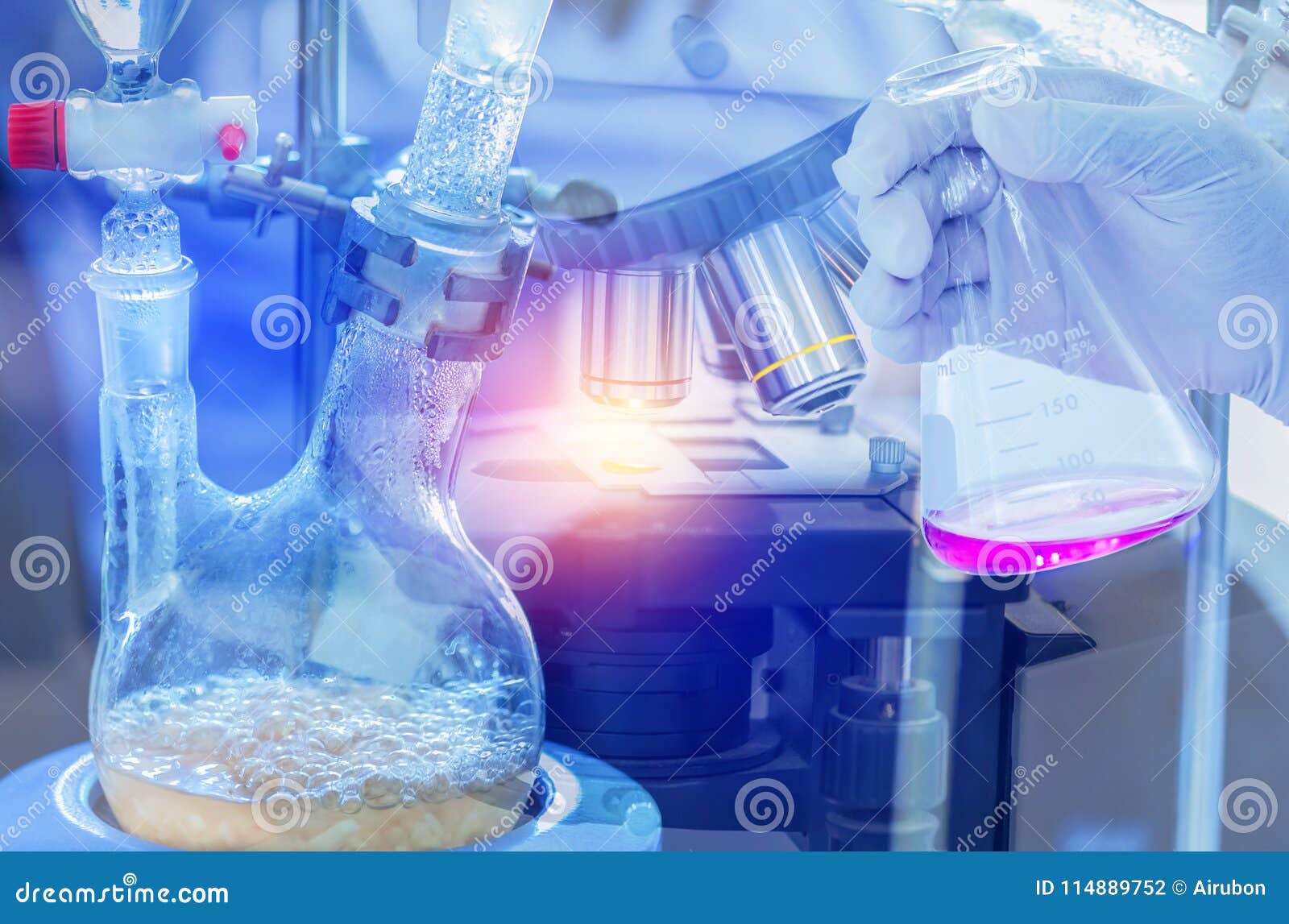 Microscope Equipment with Hand Scientist Holding Flask and Distillation ...