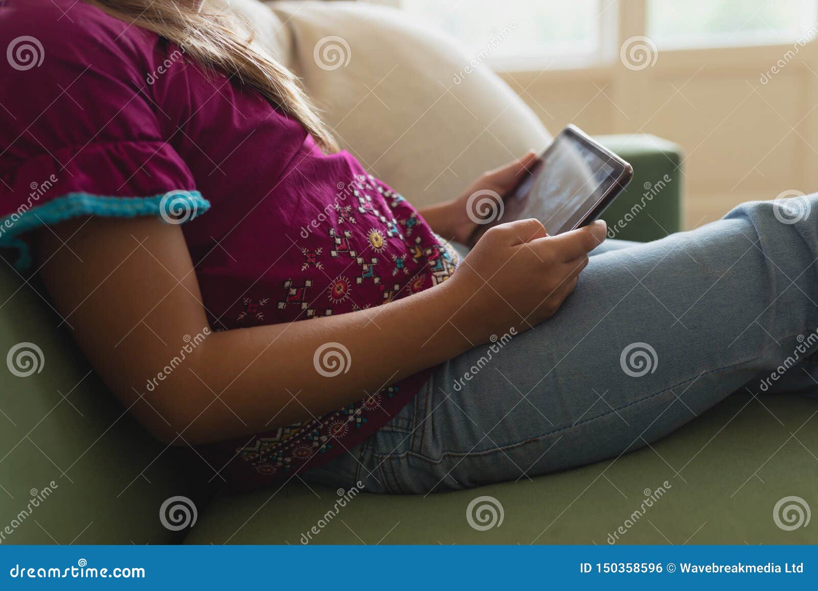 Girl Using Digital Tablet on Sofa in a Comfortable Home Stock Photo ...