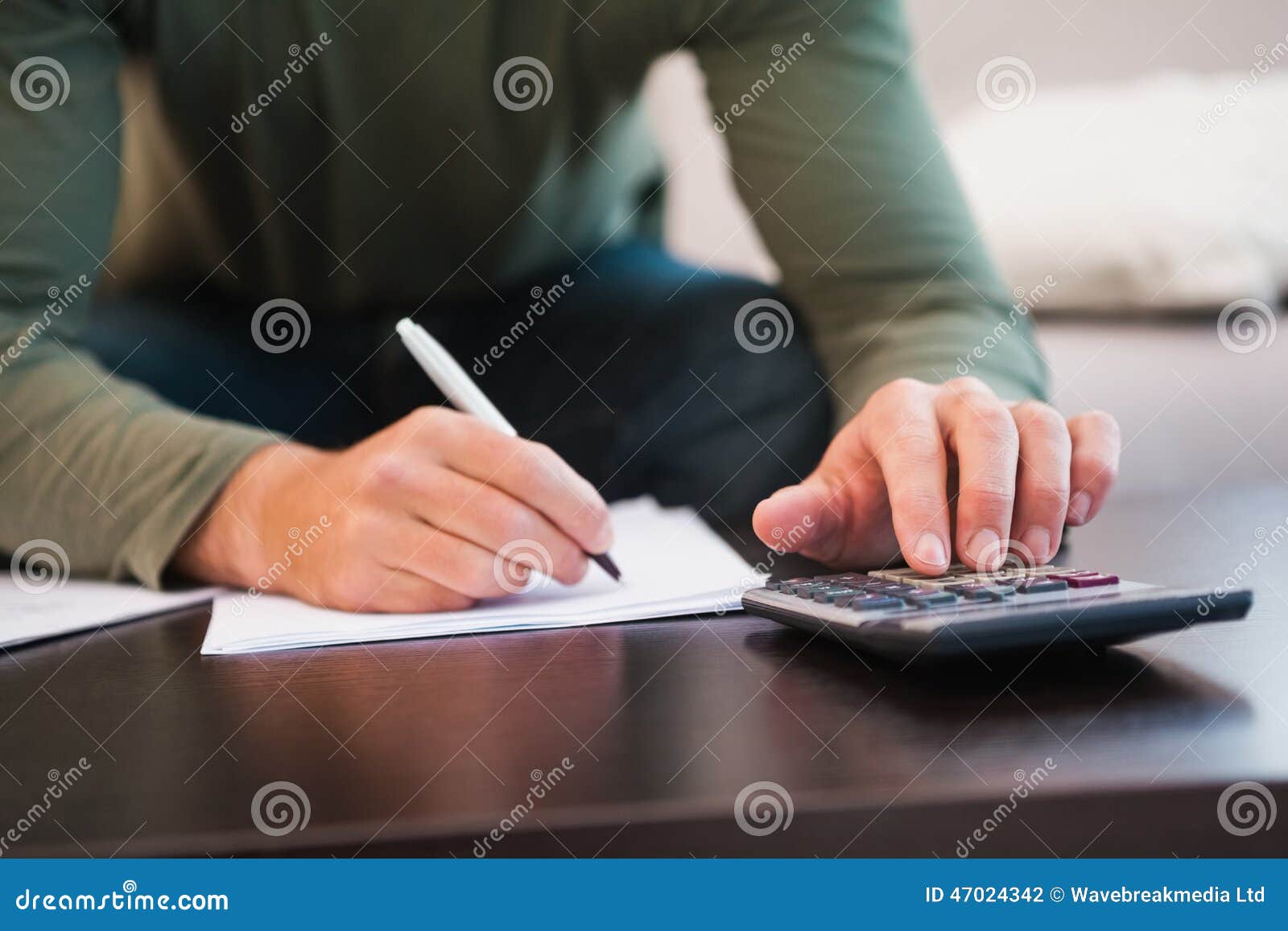 Mid Section of Man Taking Notes and Using Calculator Stock Photo ...