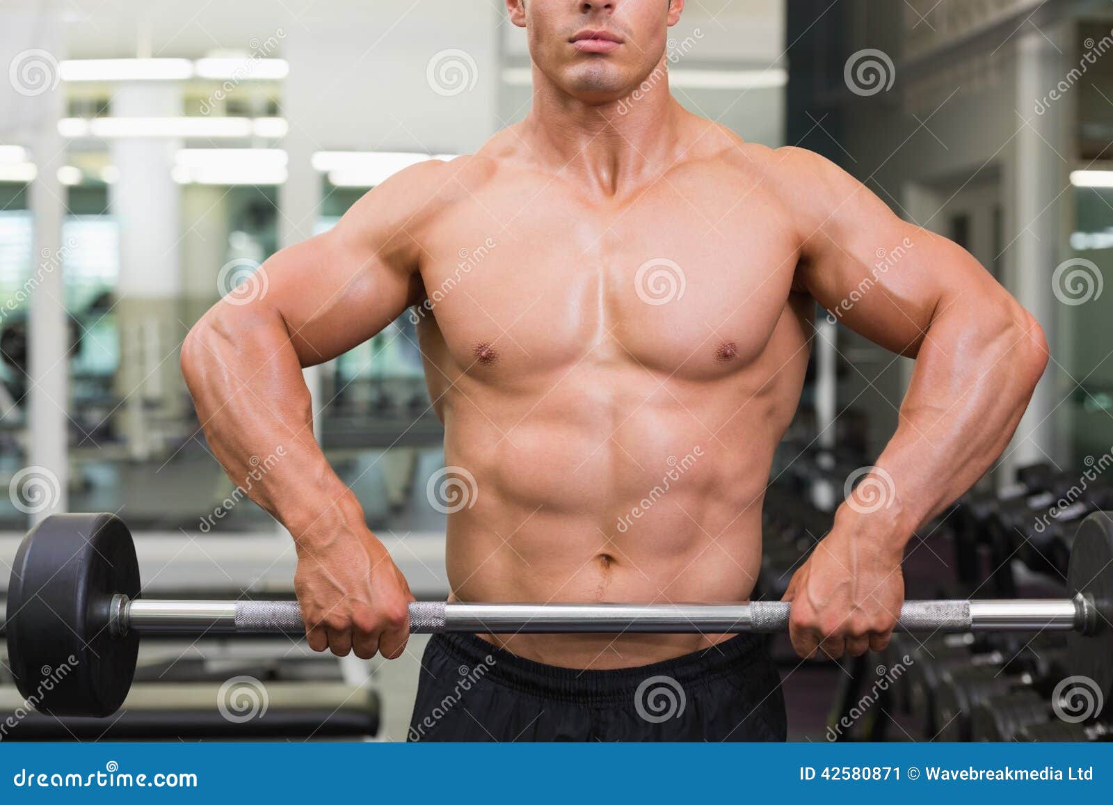 Mid Section Of A Shirtless Muscular Man Lifting Barbell Stock Image